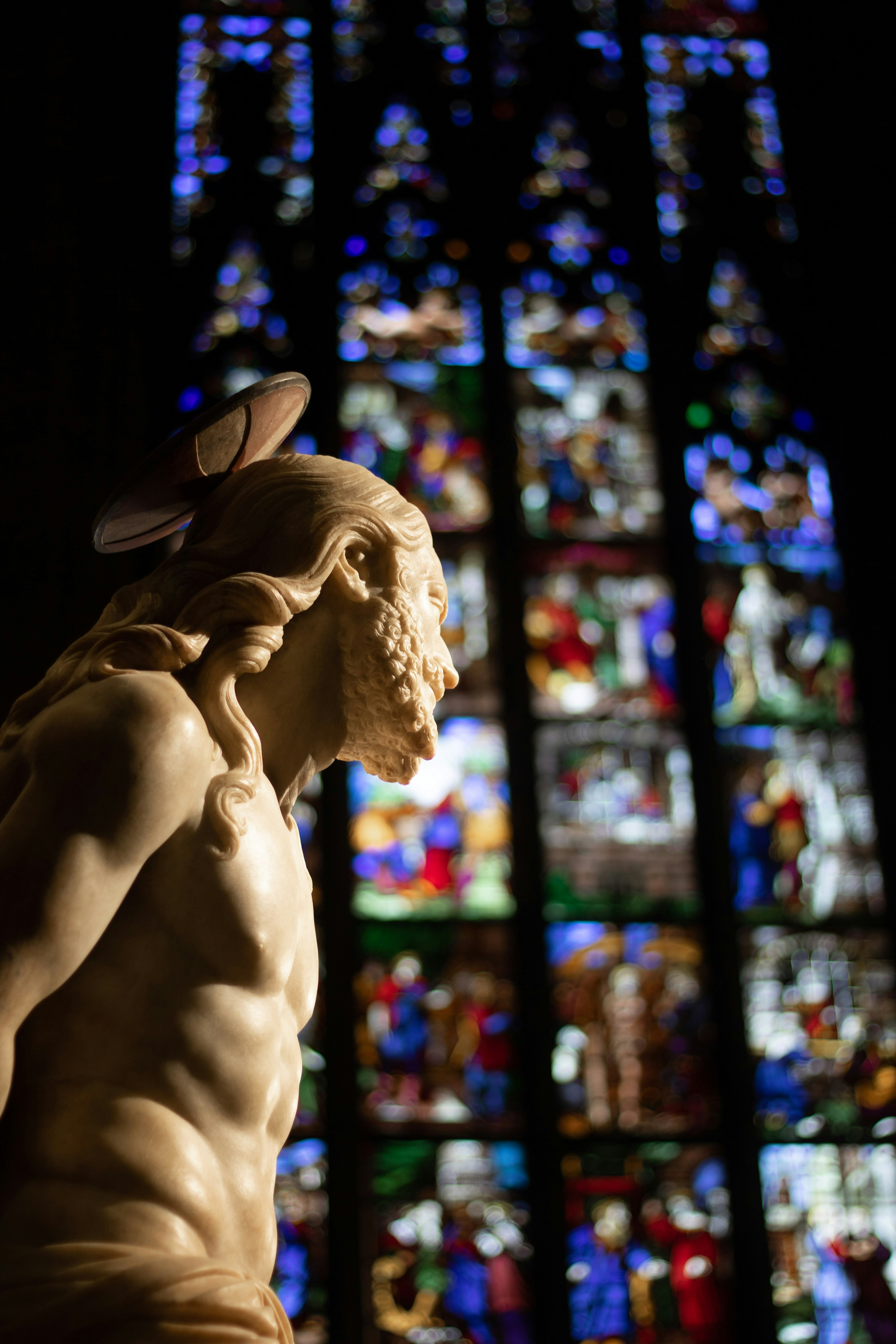 Haloed Saint in Profile Against a Cathedral's Stained-Glass Burst