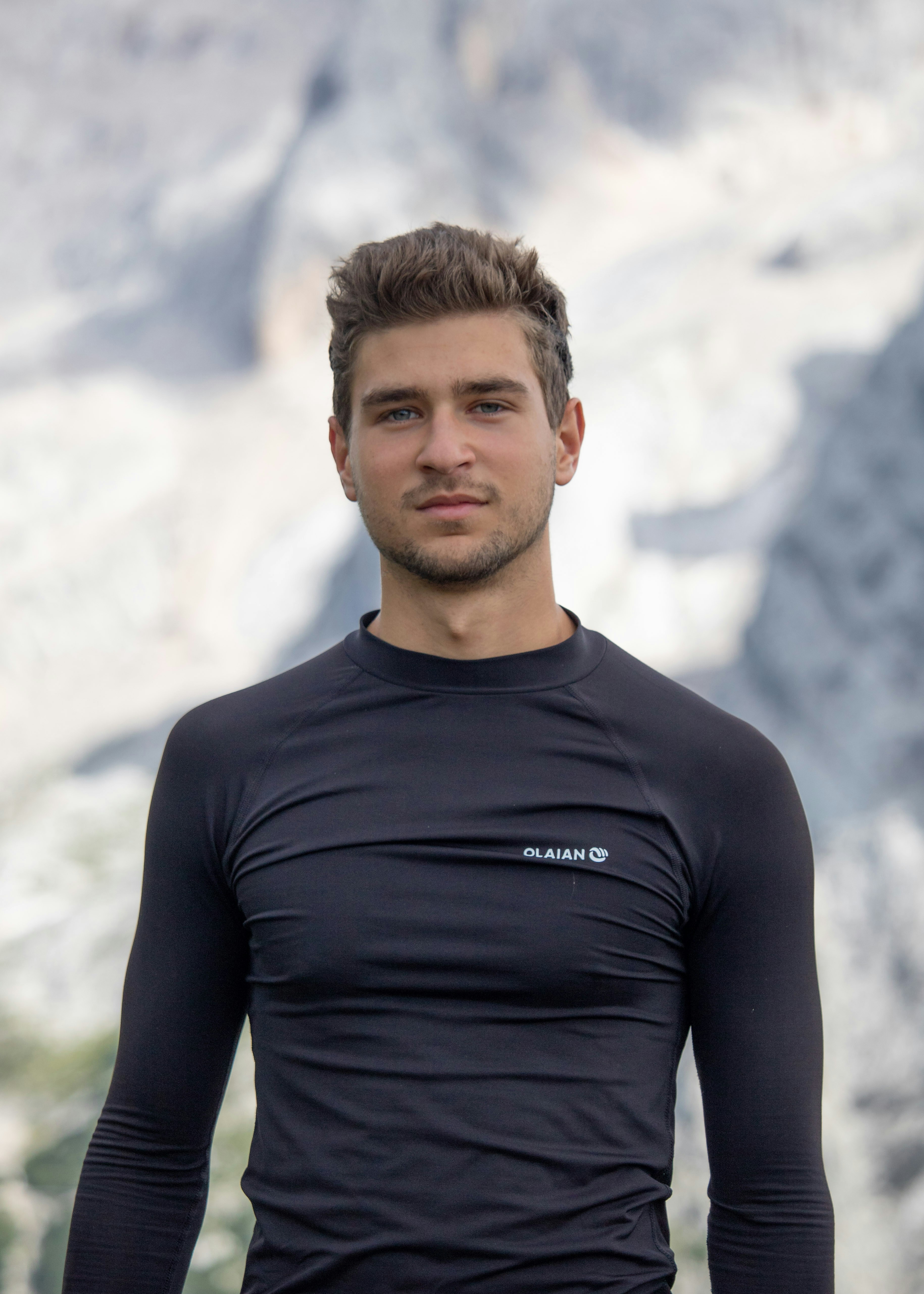 Edge of Silence: Portrait Against Weathered Alpine Cliffs