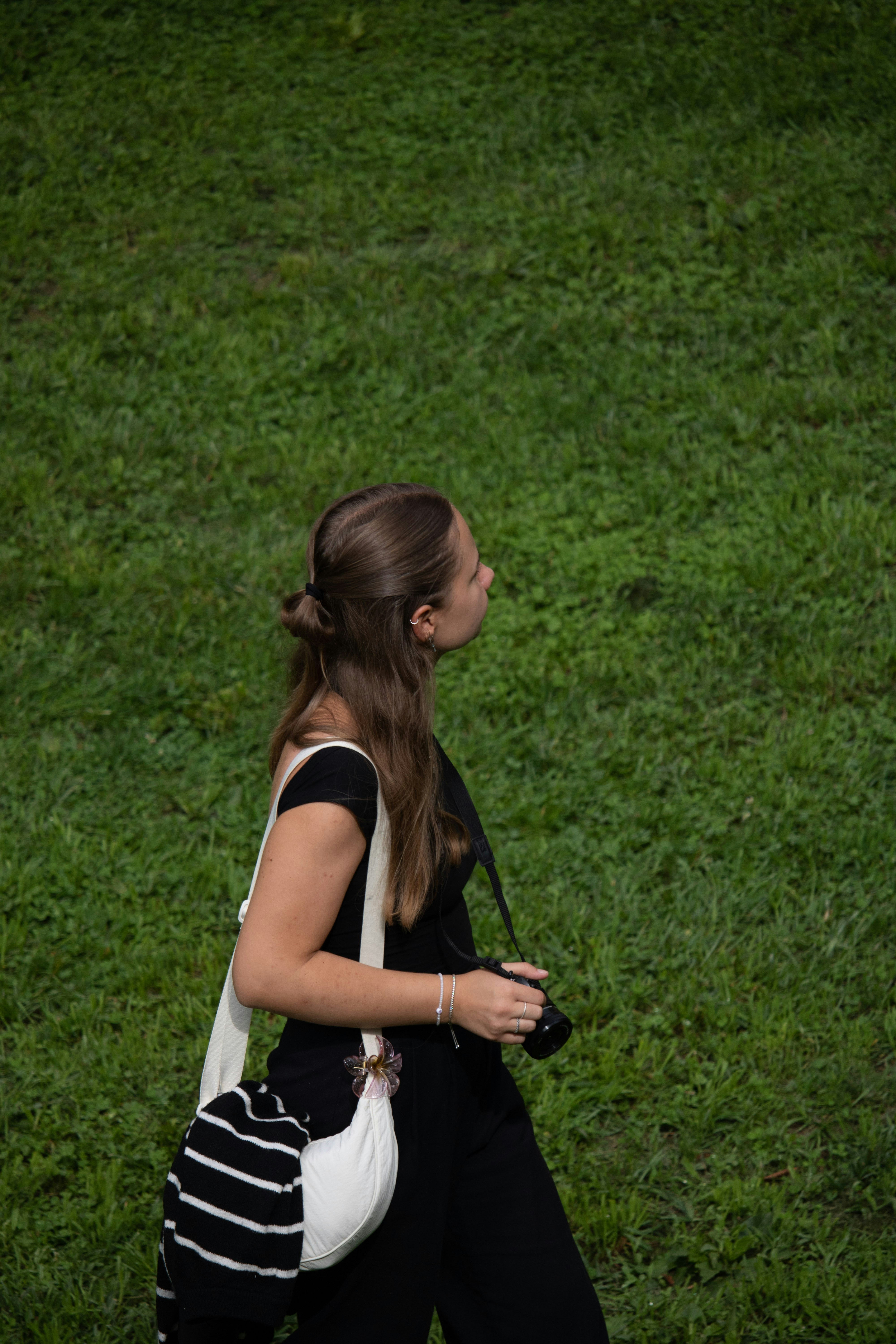 Quiet Portrait in the Meadow: A Photographer Pausing with Camera