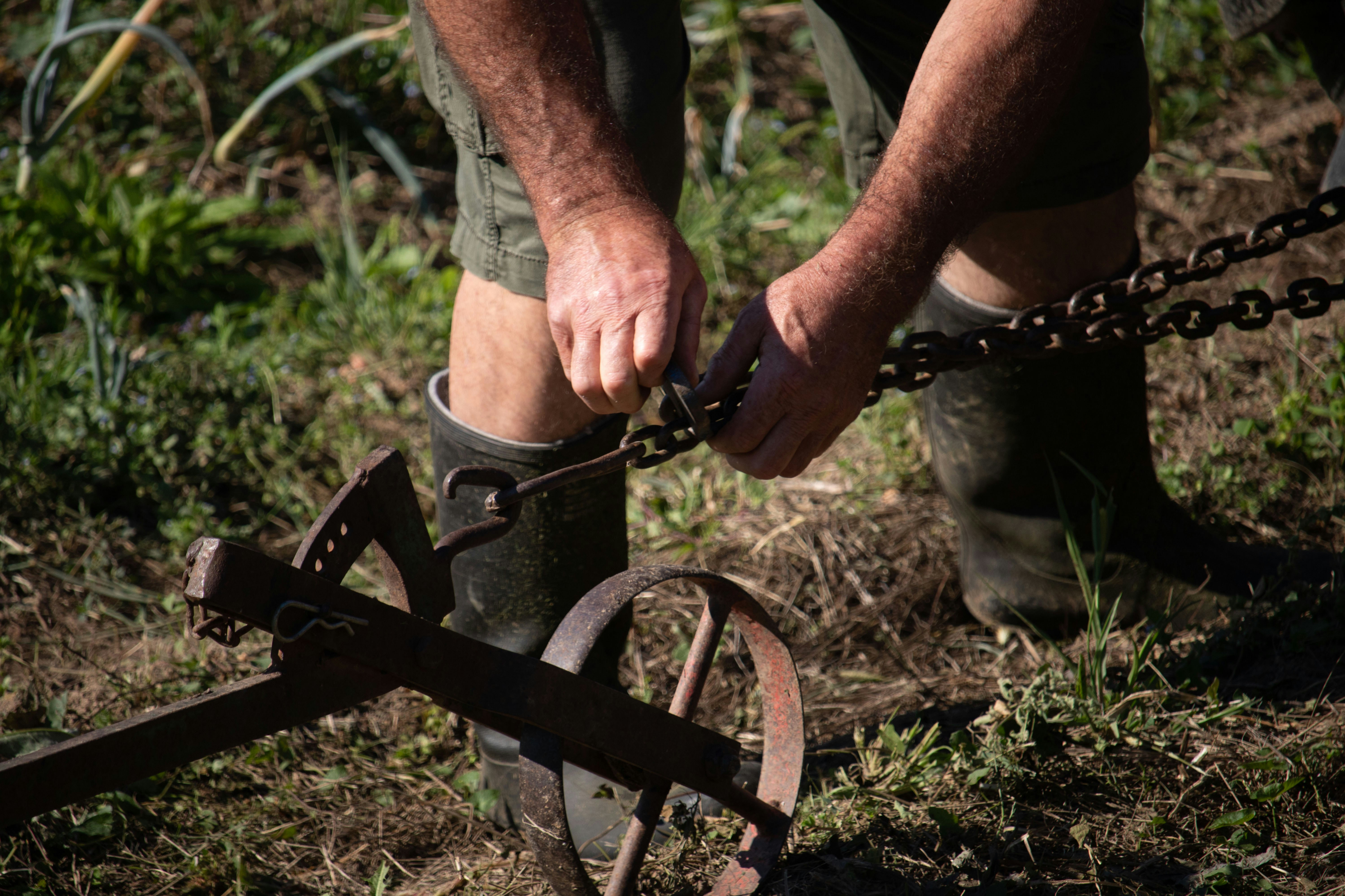 Close-Quarters Craft: Hands Fasten a Chain to a Steel Trap in Rough Terrain