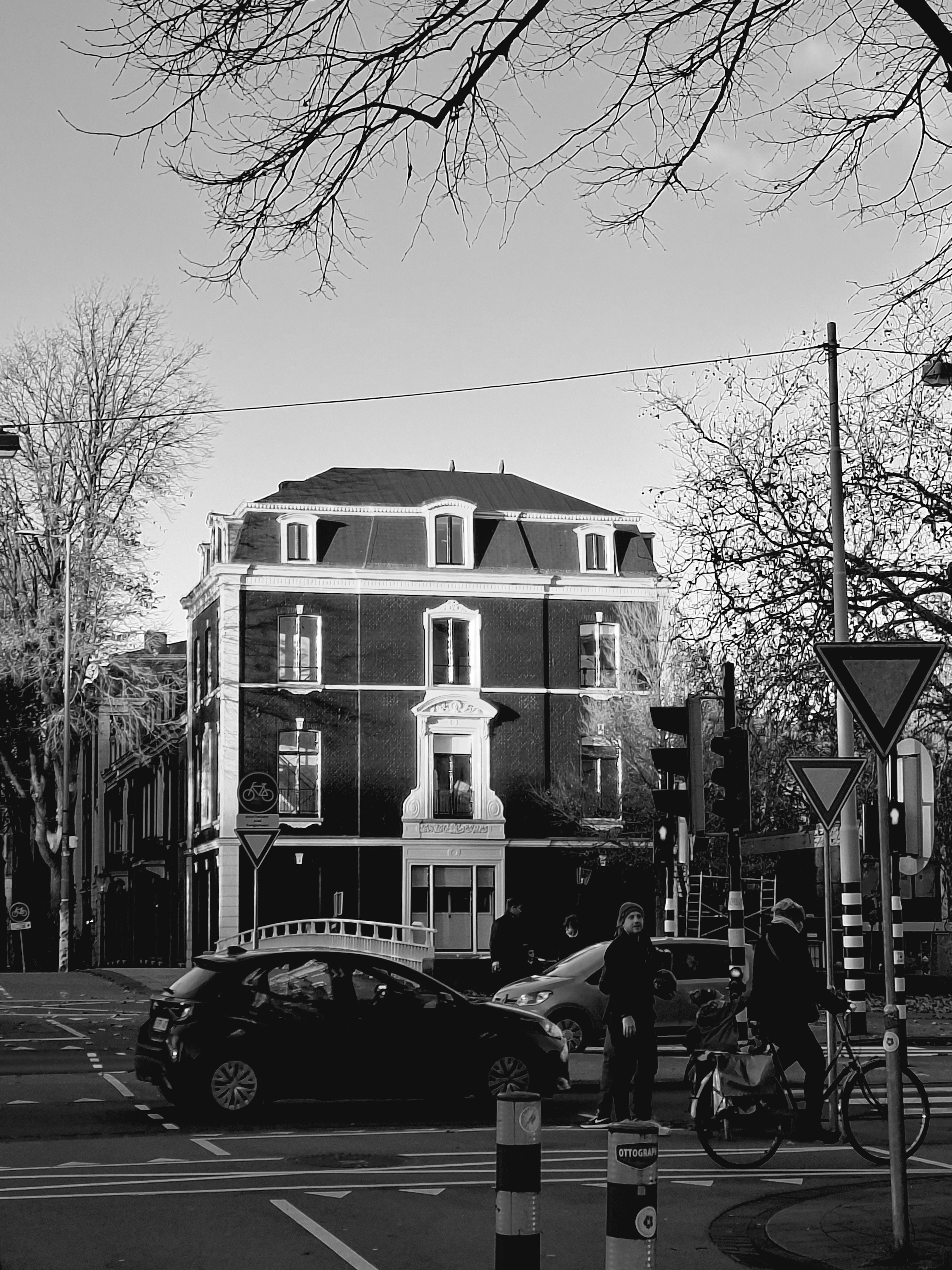 City street with building, cars, and pedestrians