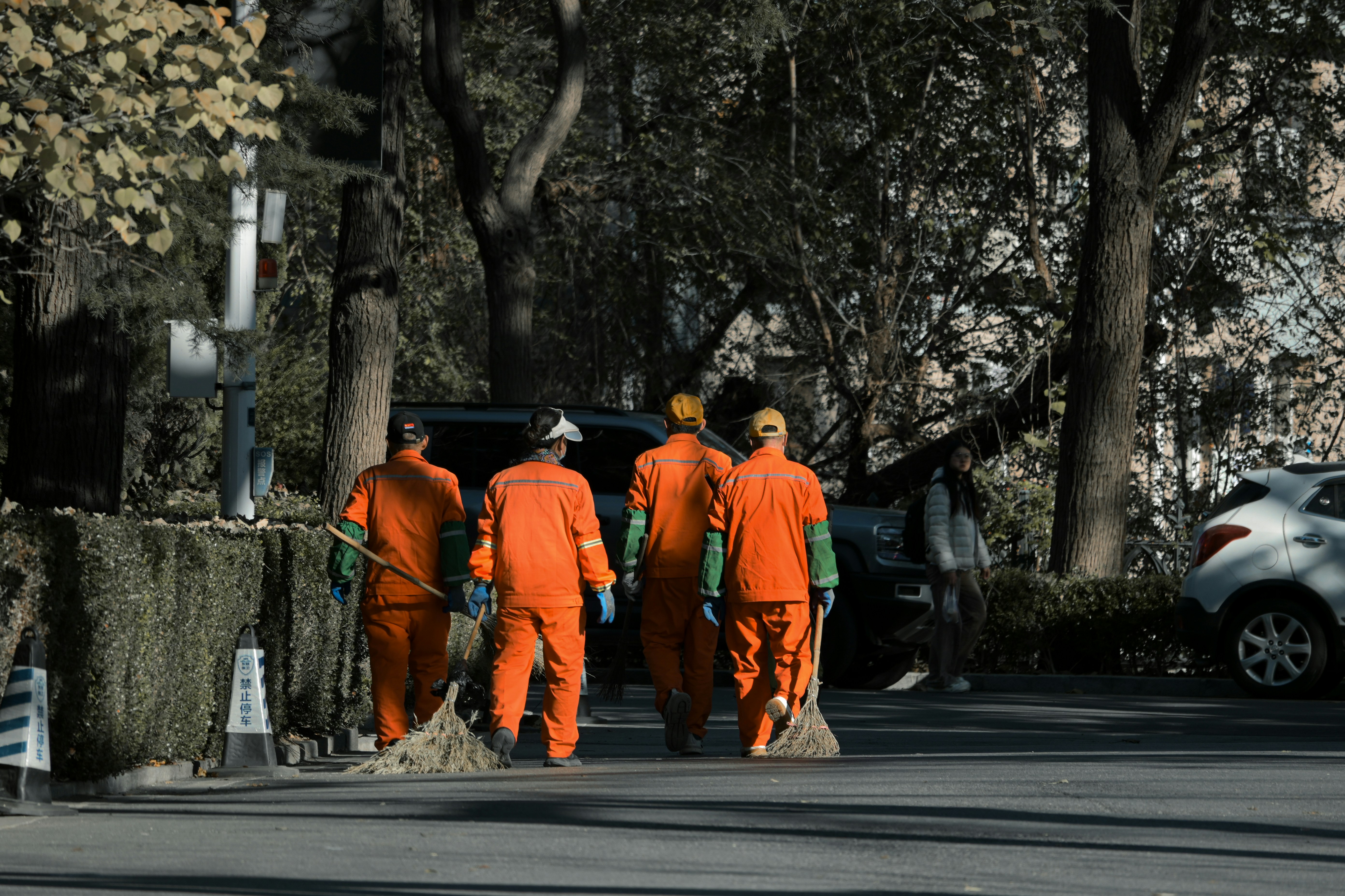 Four sanitation workers in orange uniforms with brooms photo – Free ...