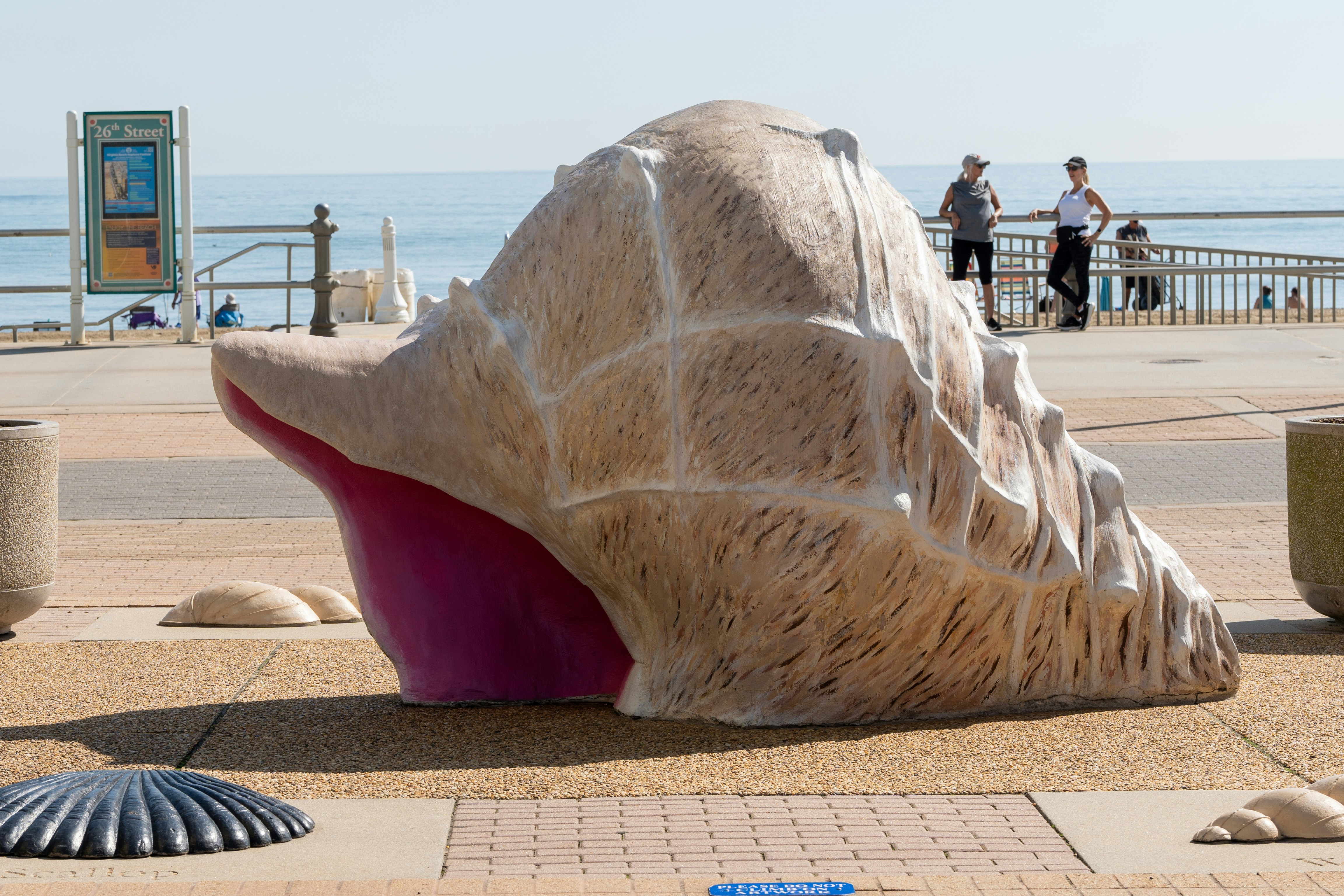 Sun-bleached Conch Sculpture Gracing a Seaside Boardwalk
