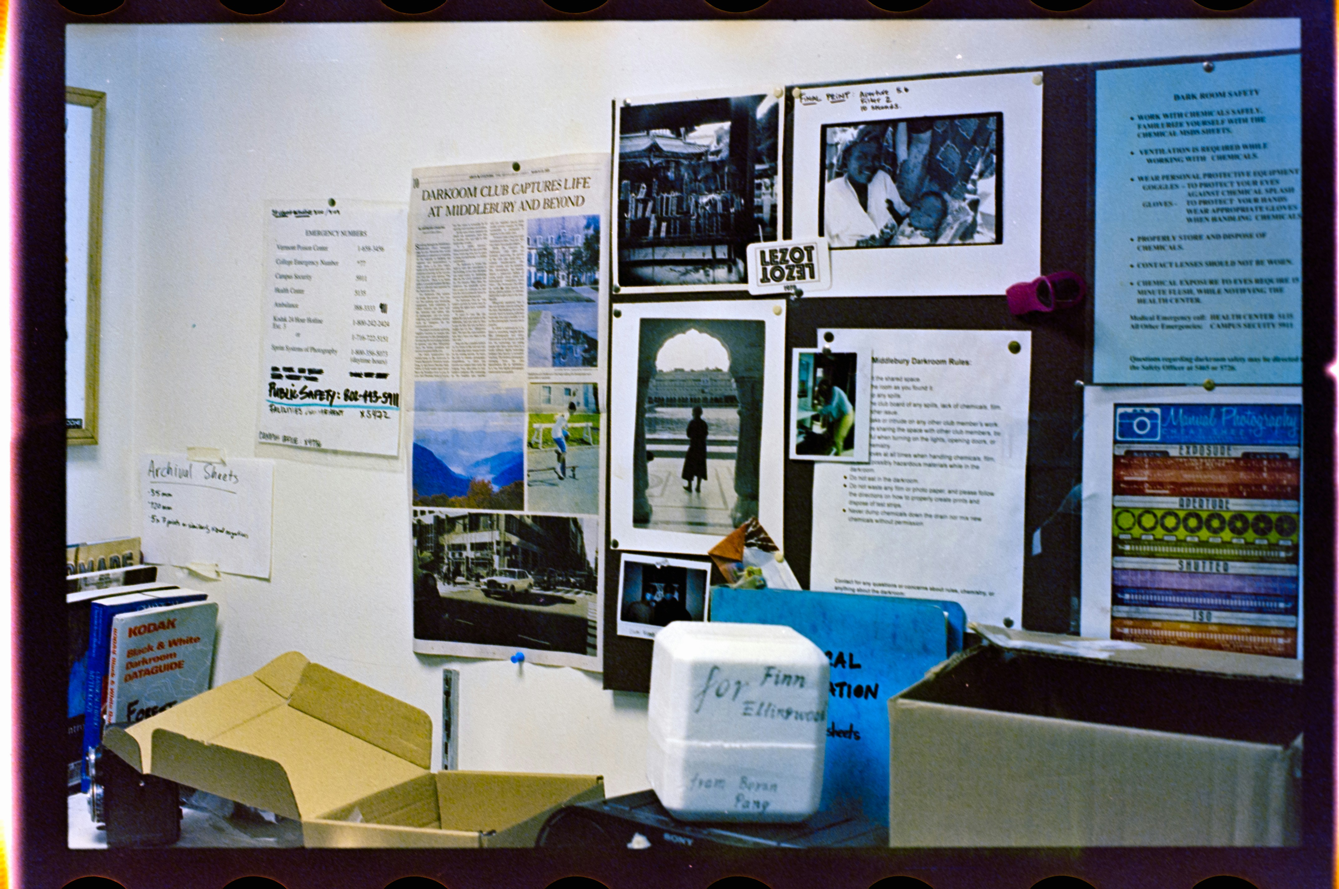 Bulletin board with papers, photos, and boxes on desk. photo – Free ...