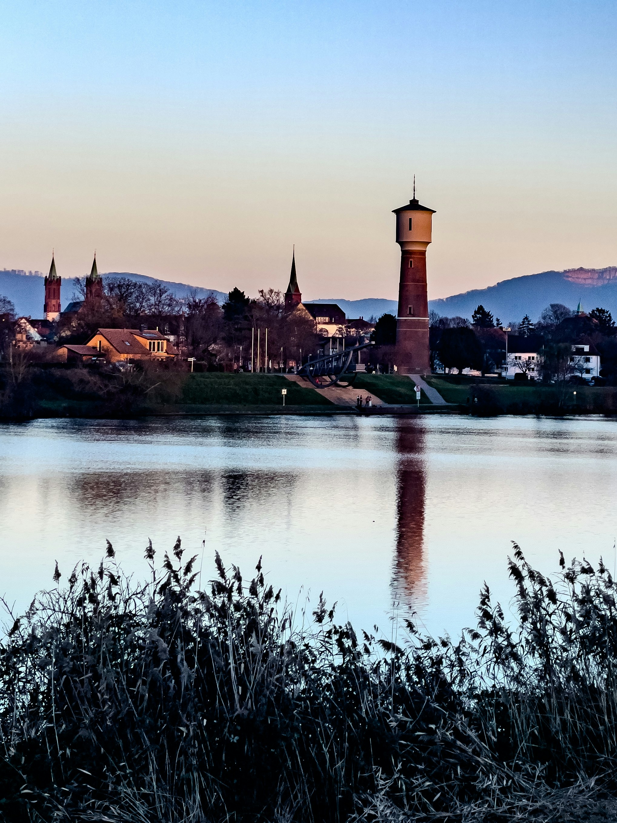 Evening Beacon Over the River: A Towered Town Reflected in Calm Waters