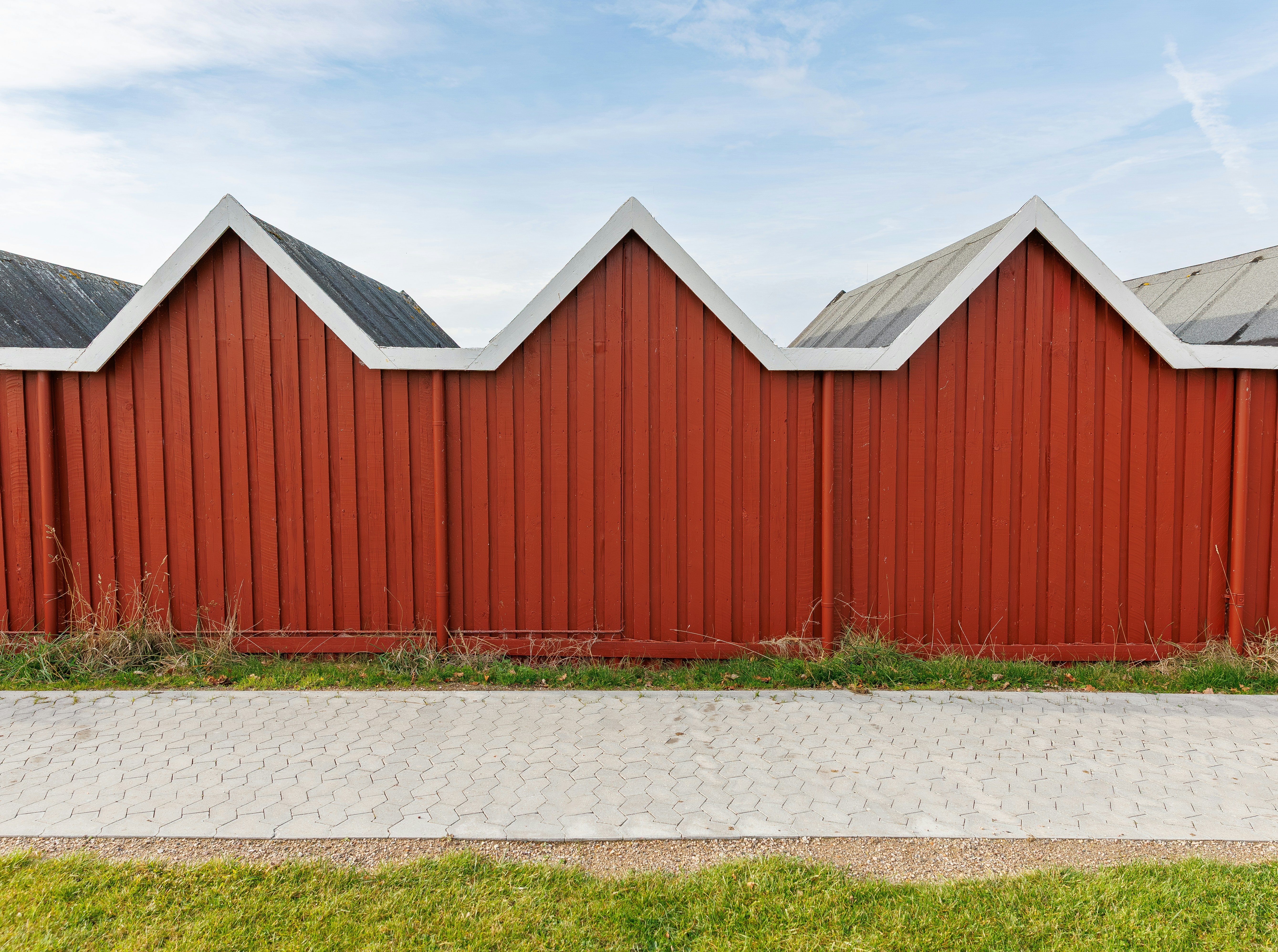 Traditional Red Wooden Huts with Distinctive White Zigzag Roofline
