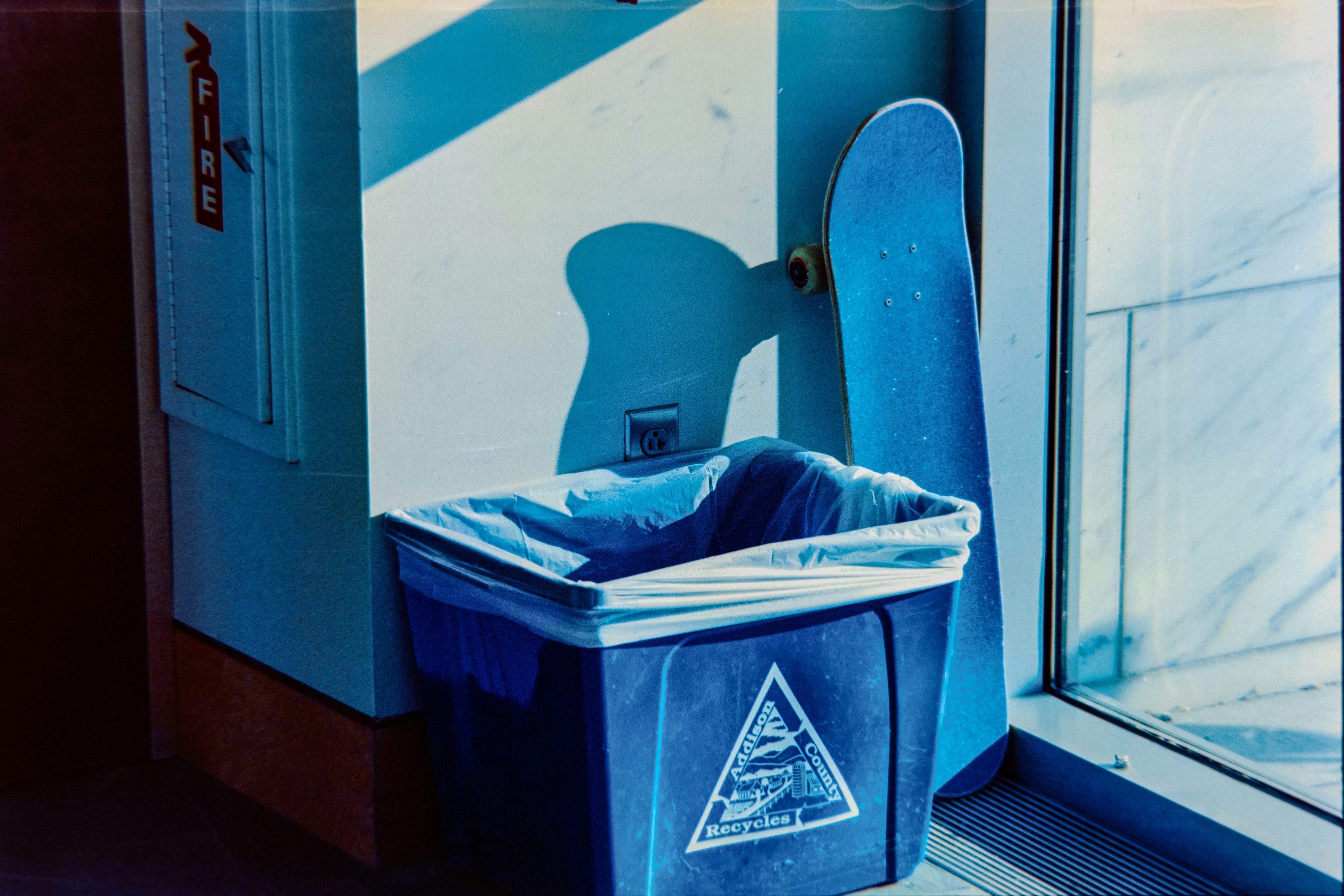 Cerulean Bin by the Window: A Quiet Blue Corner with a Skateboard