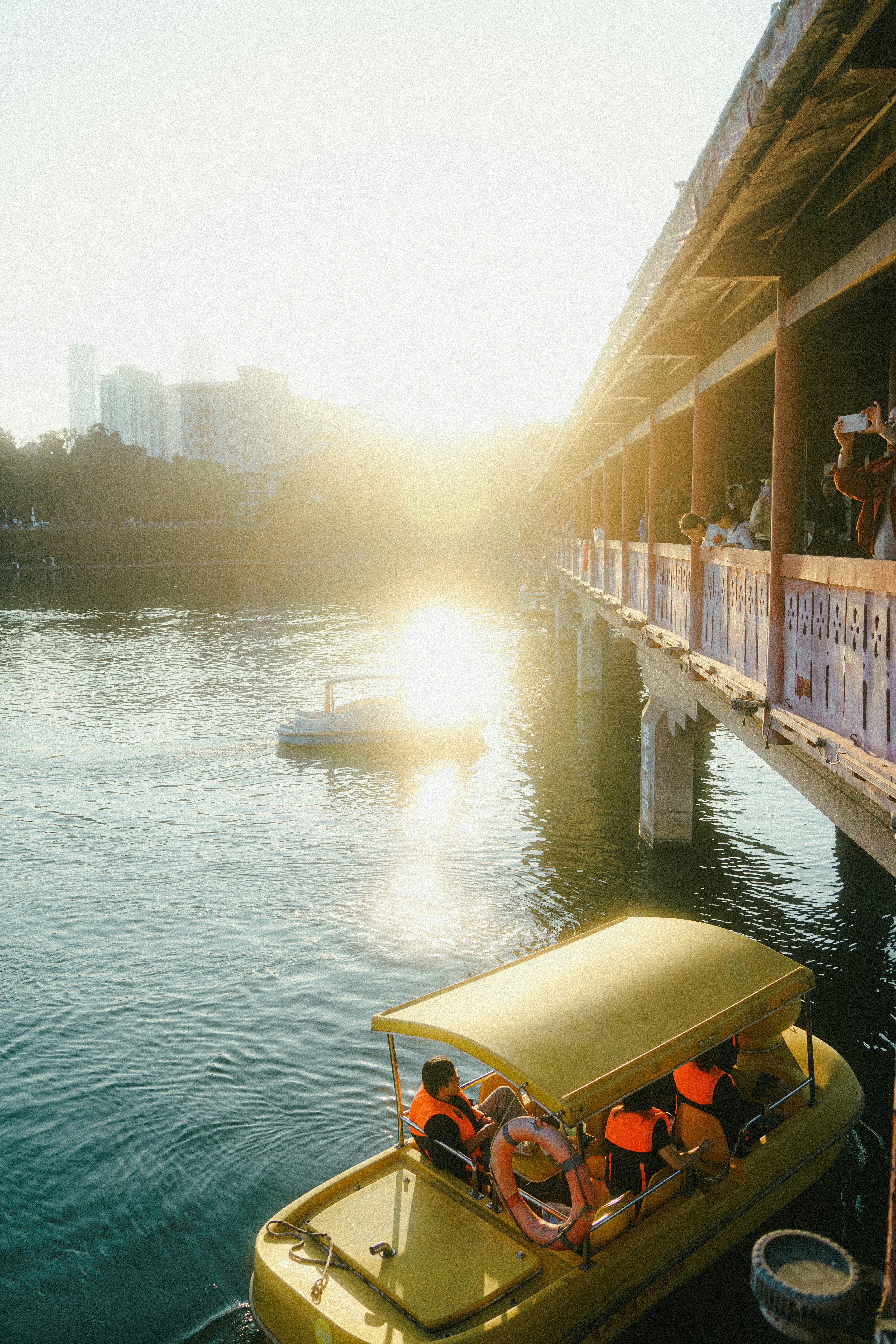 Golden Hour Cadence: A Yellow Boat Gliding Under a Wooden Pier