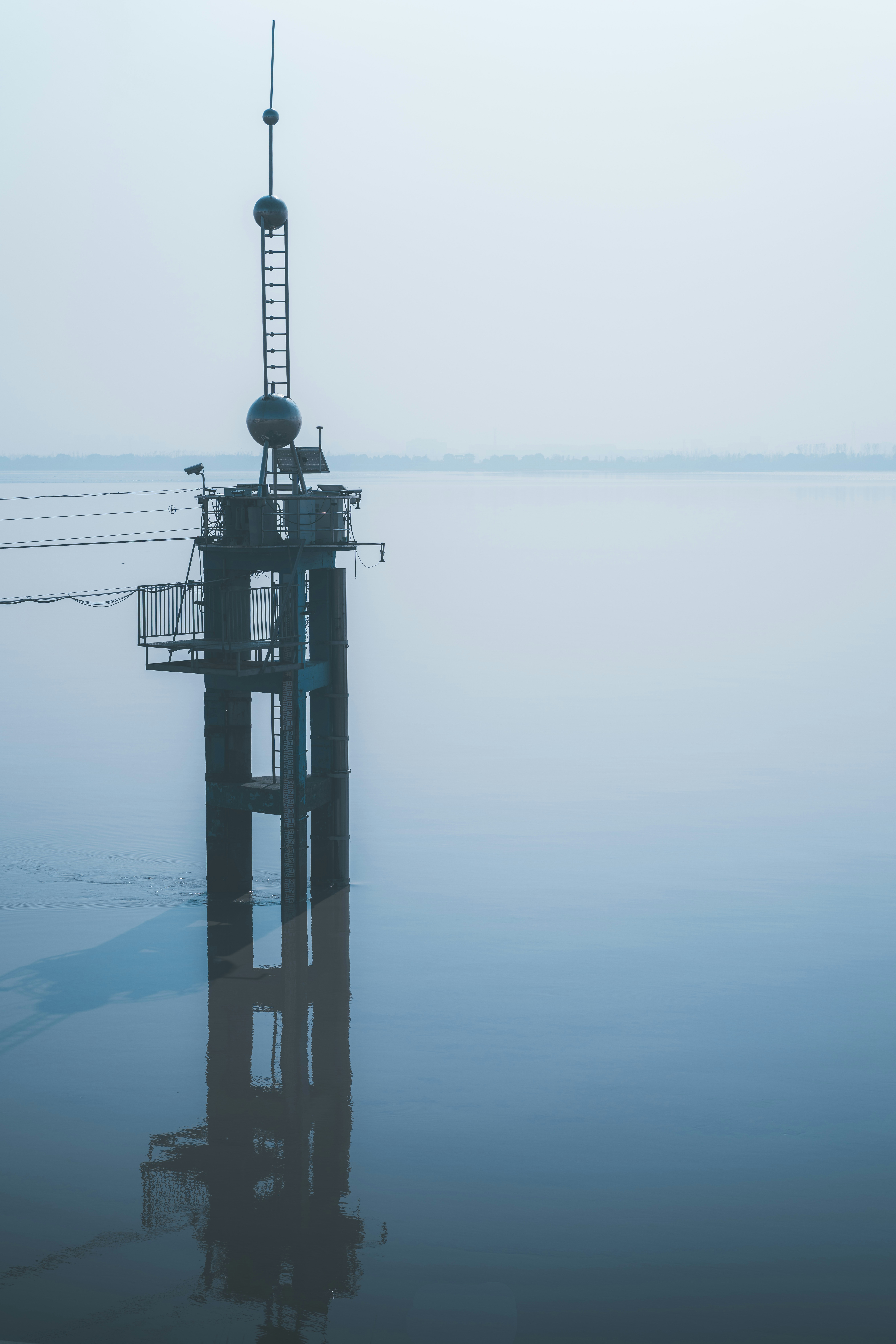 Mist-Blue Sentinel: A Quiet Tower Rising from a Glassy Lake