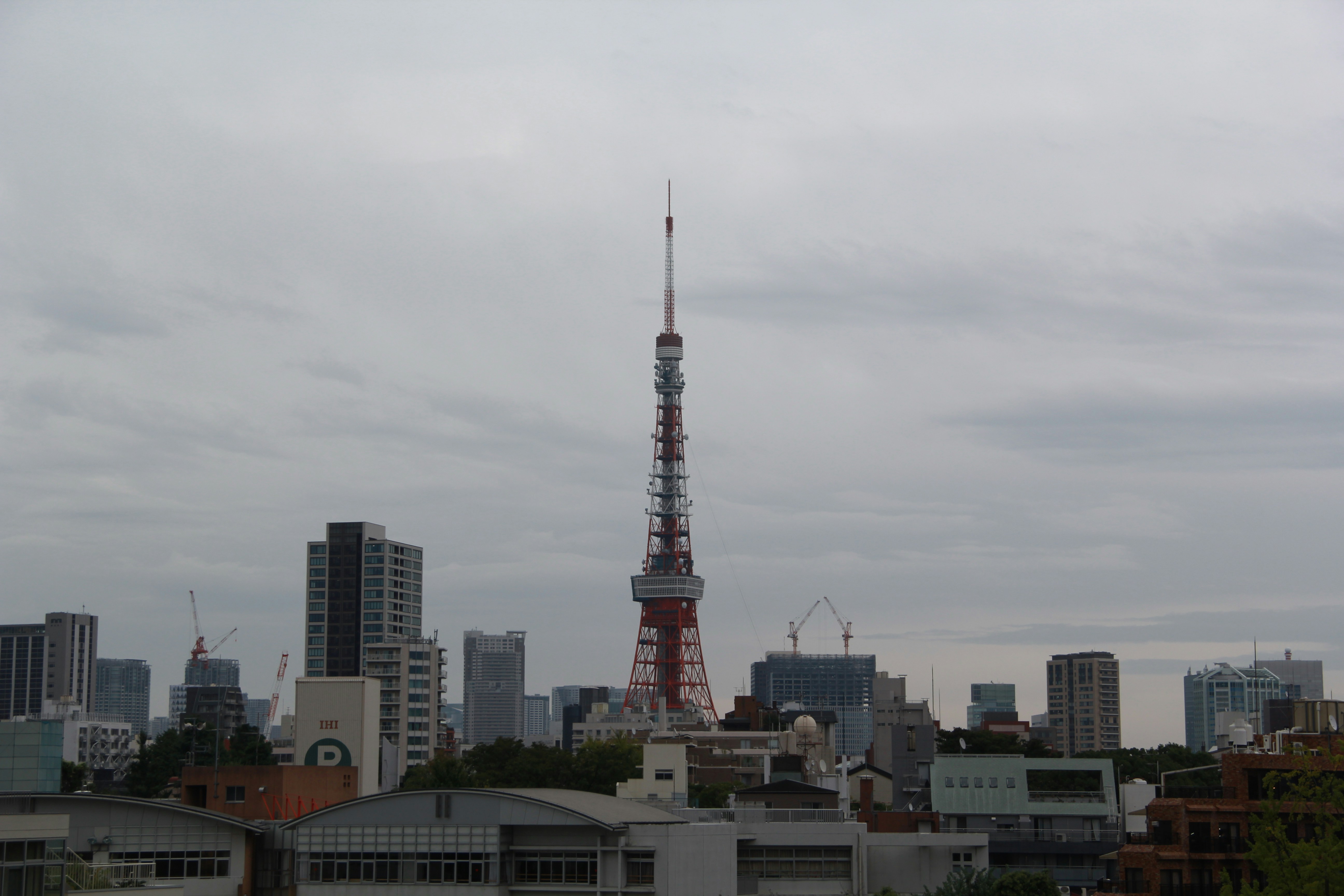 Red-and-White Tower Rising Over a Gray Cityscape