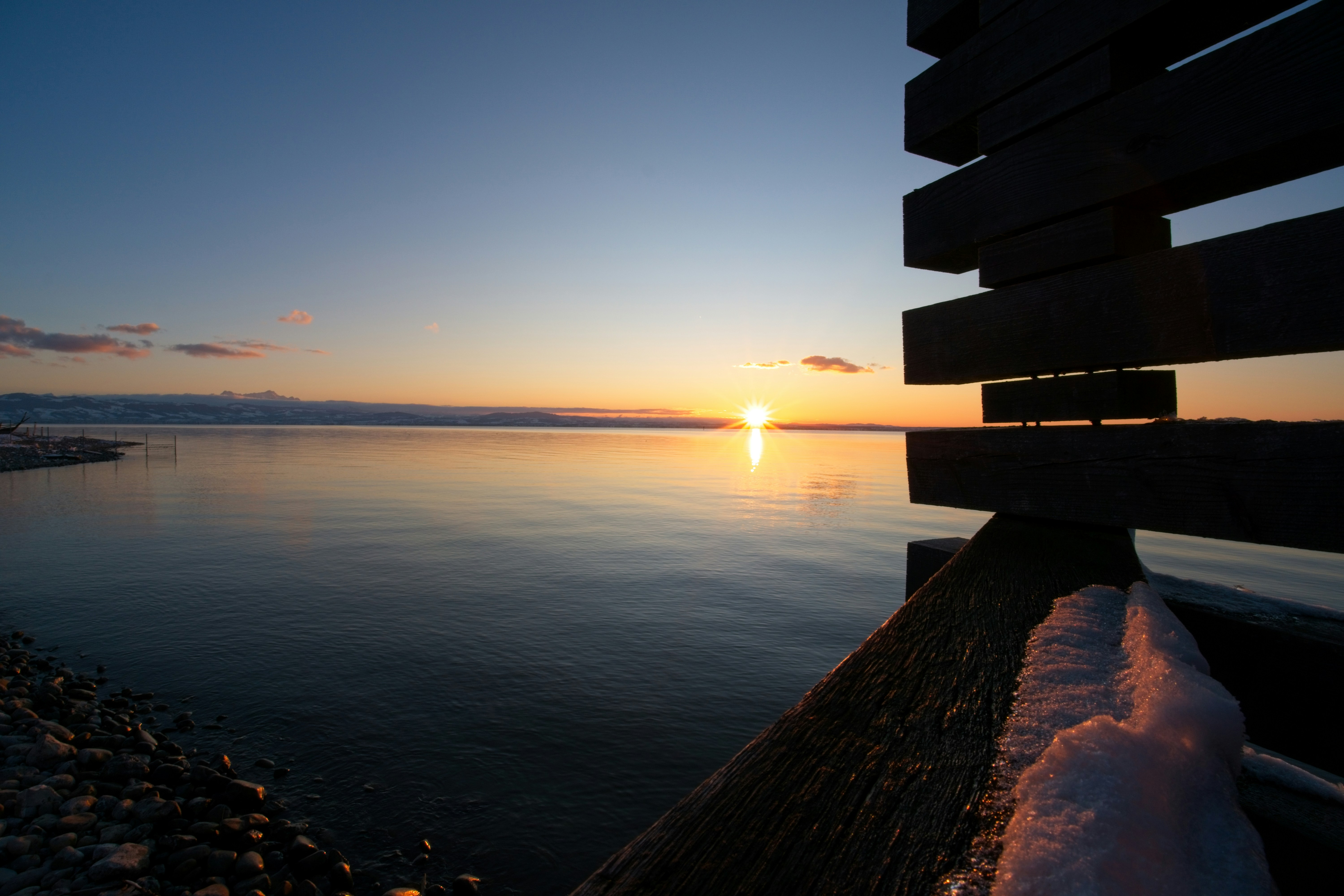 Horizon's Quiet Fire Beyond the Snow-Kissed Pier