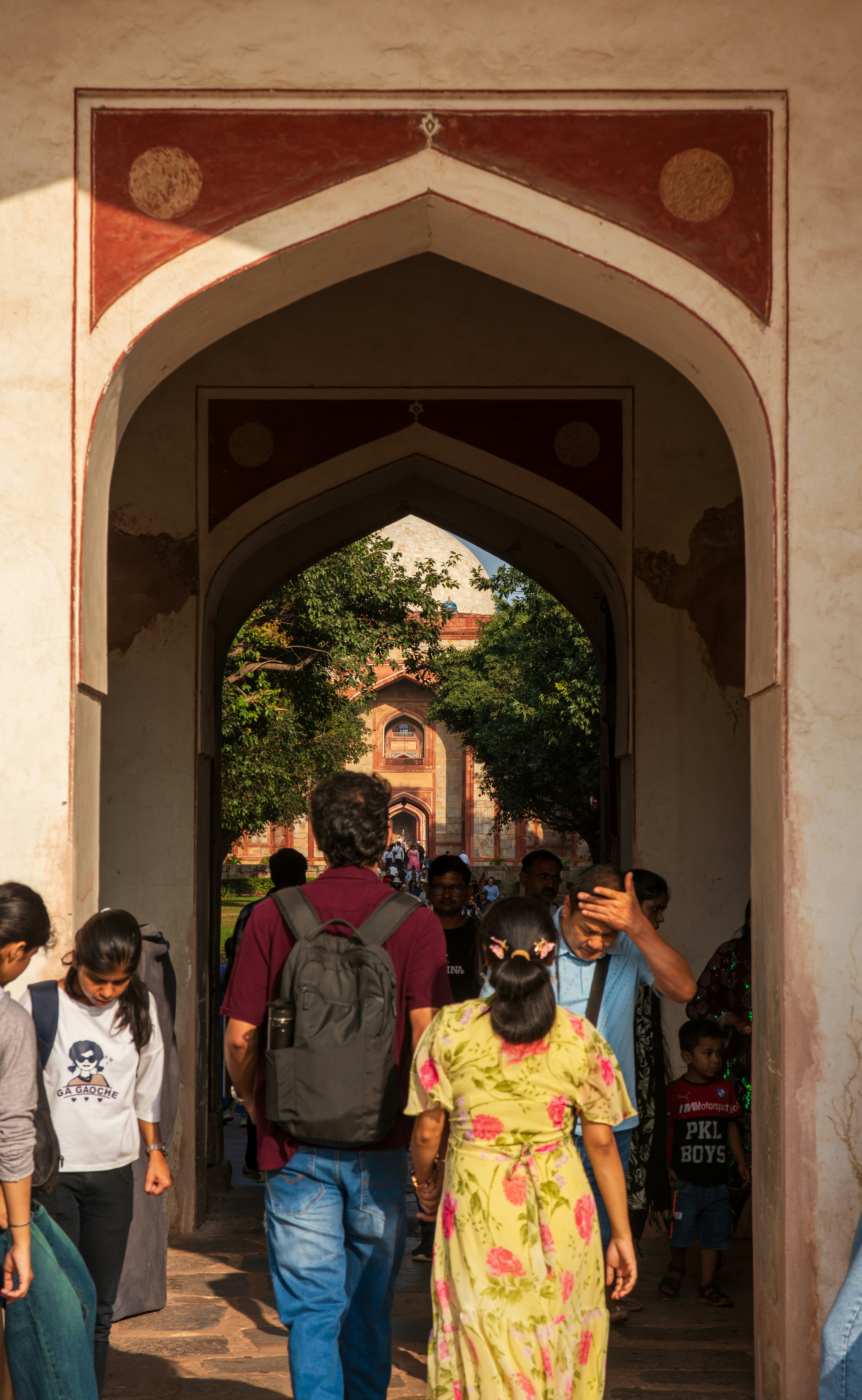 Through the Arch: a sunlit corridor toward a red-brick courtyard