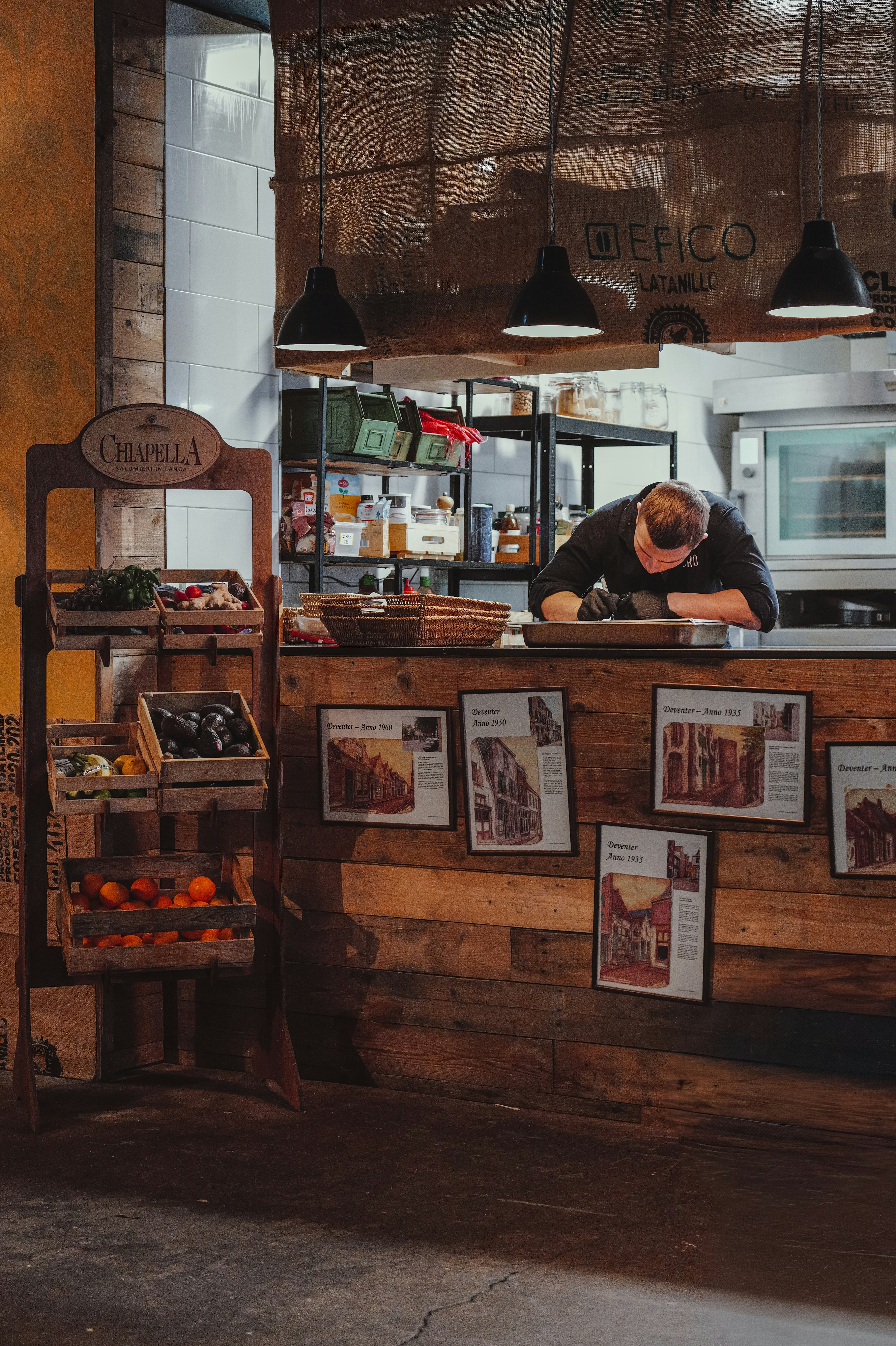 Chef working behind a wooden counter in a restaurant.