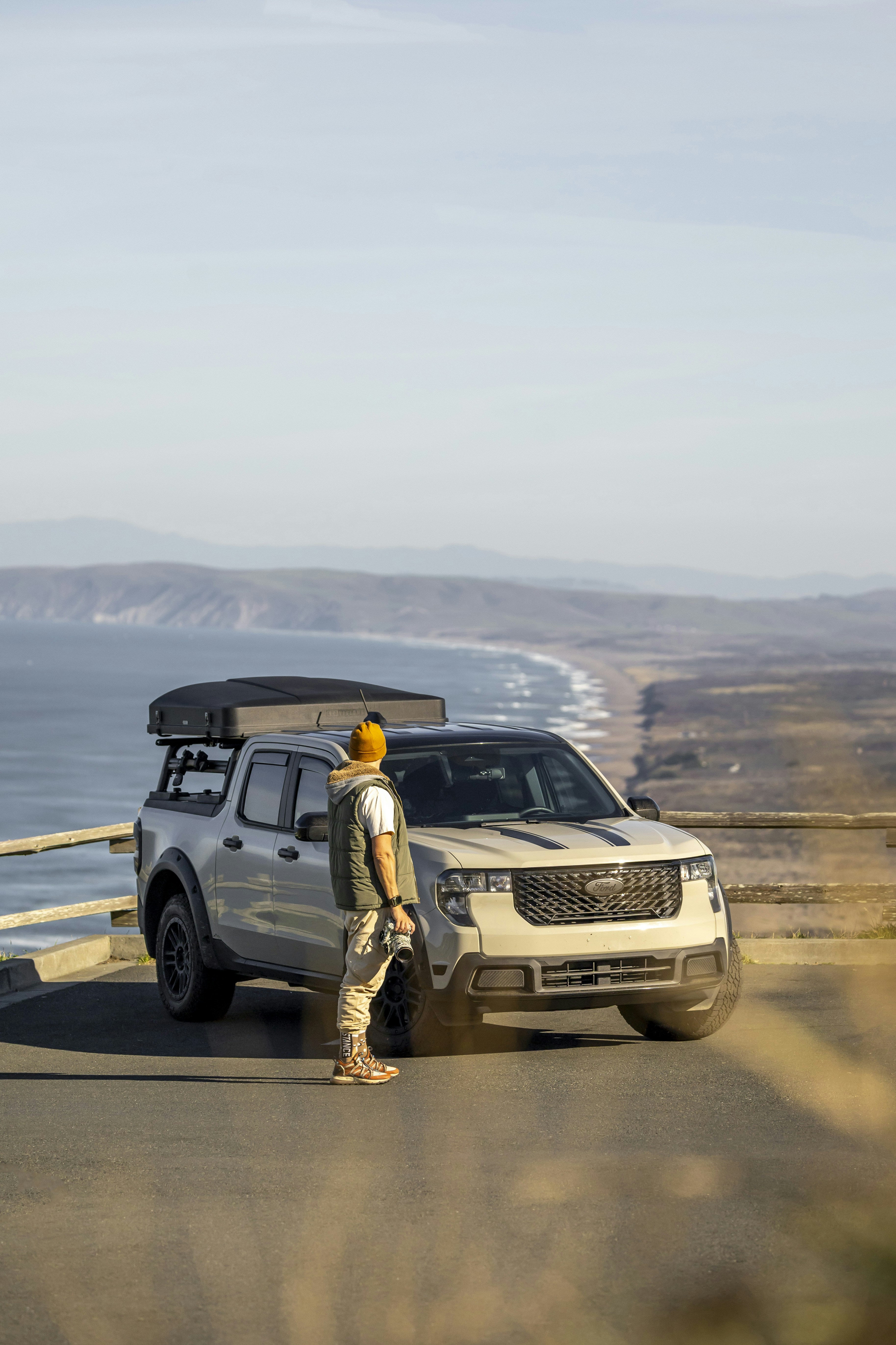 Cliffside Stopover: A lone traveler beside a rugged pickup by the sea
