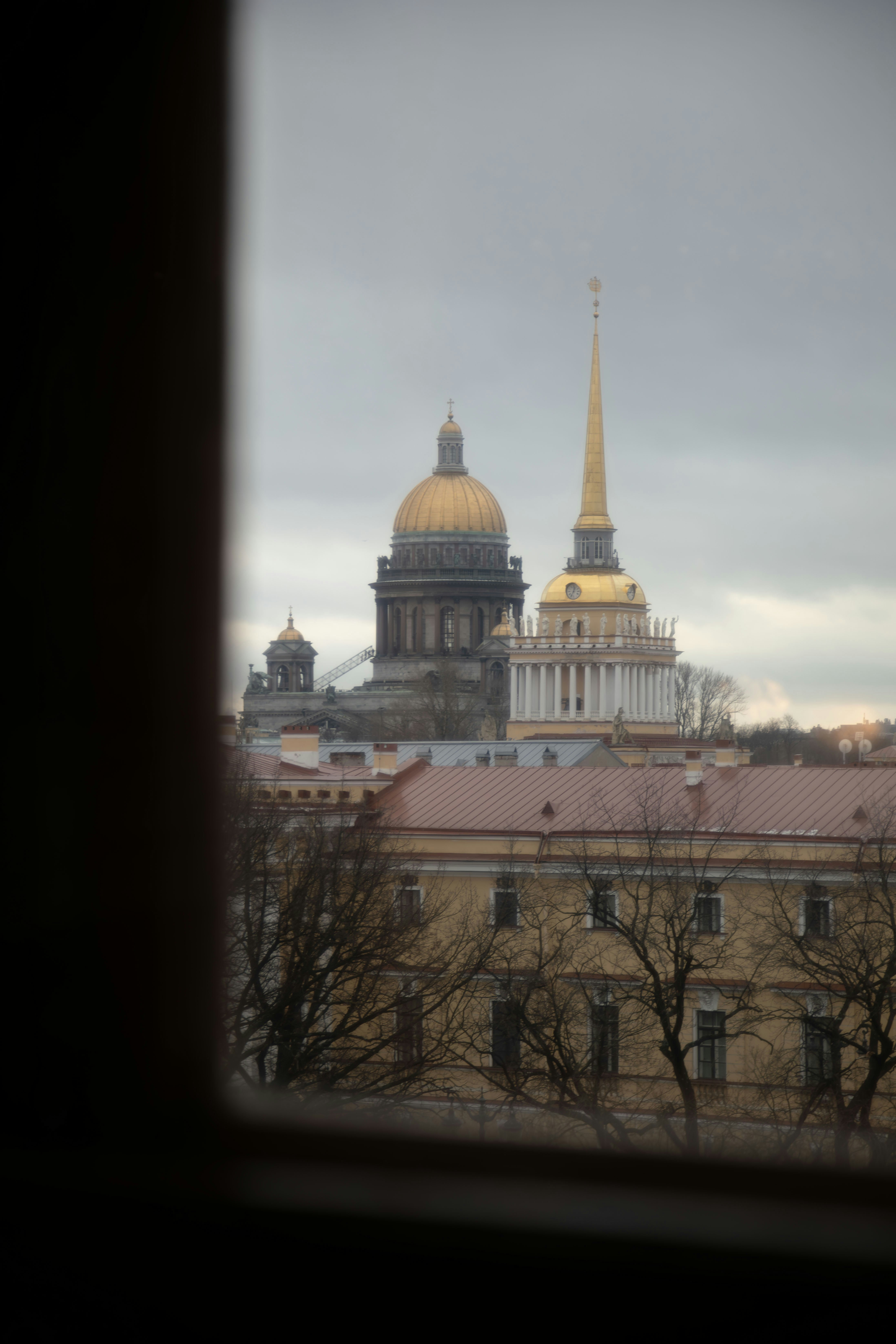 Gilded Dome Over a Quiet Cityscape, Seen Through a Window