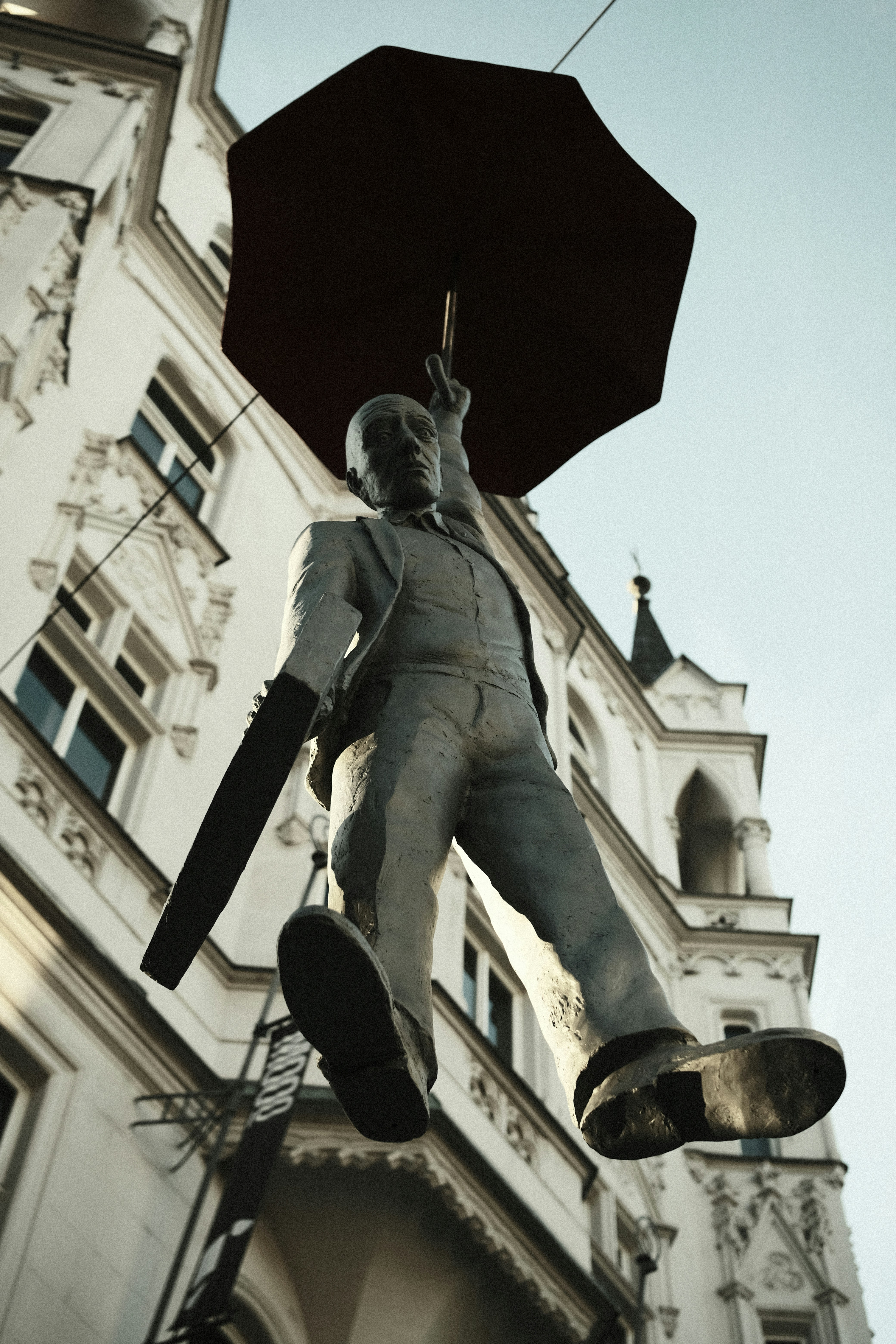 Suspended Man in a Suit Under a Giant Umbrella