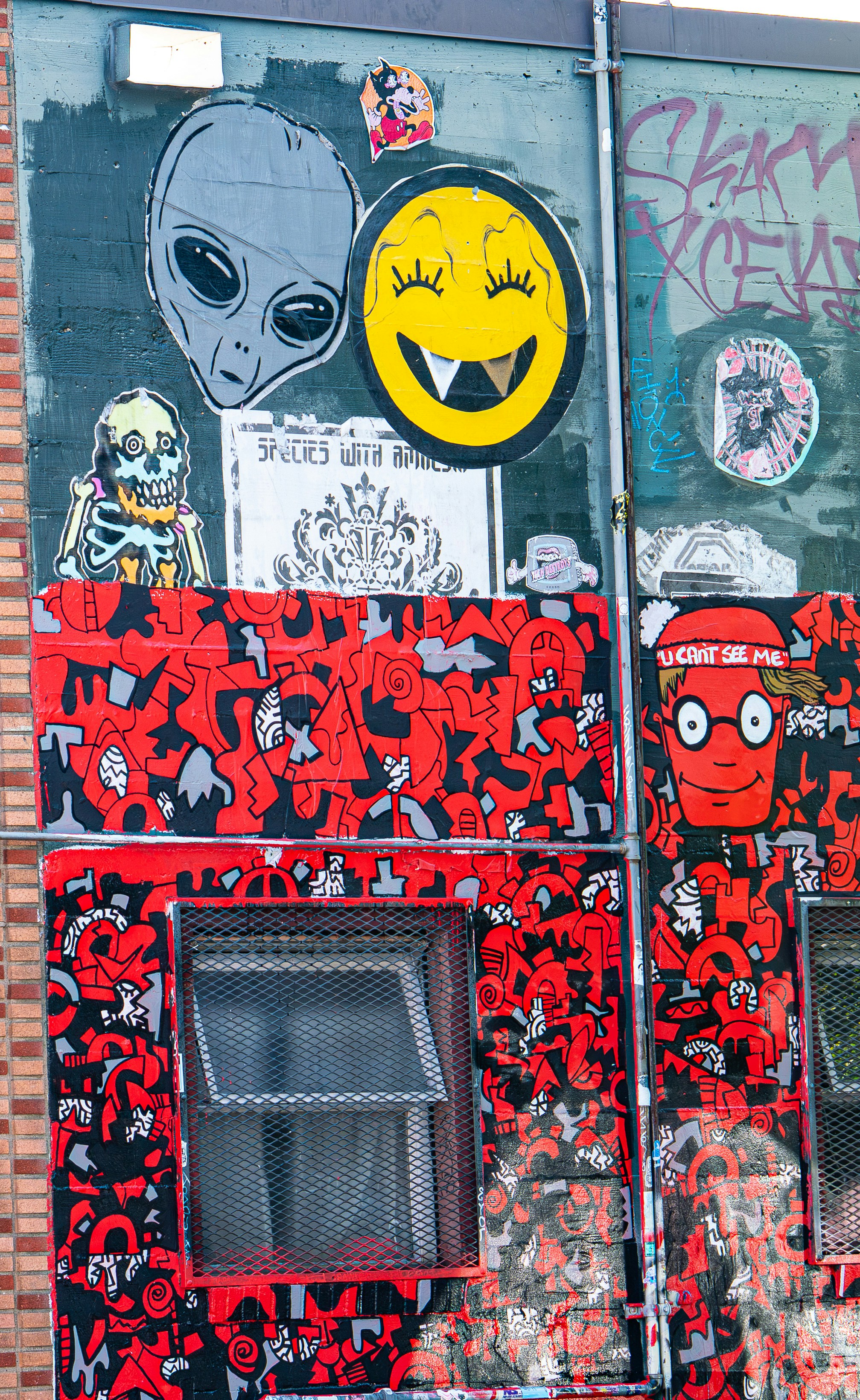 Grin on the Street: A Yellow Emoji Anchors a Graffiti Mosaic