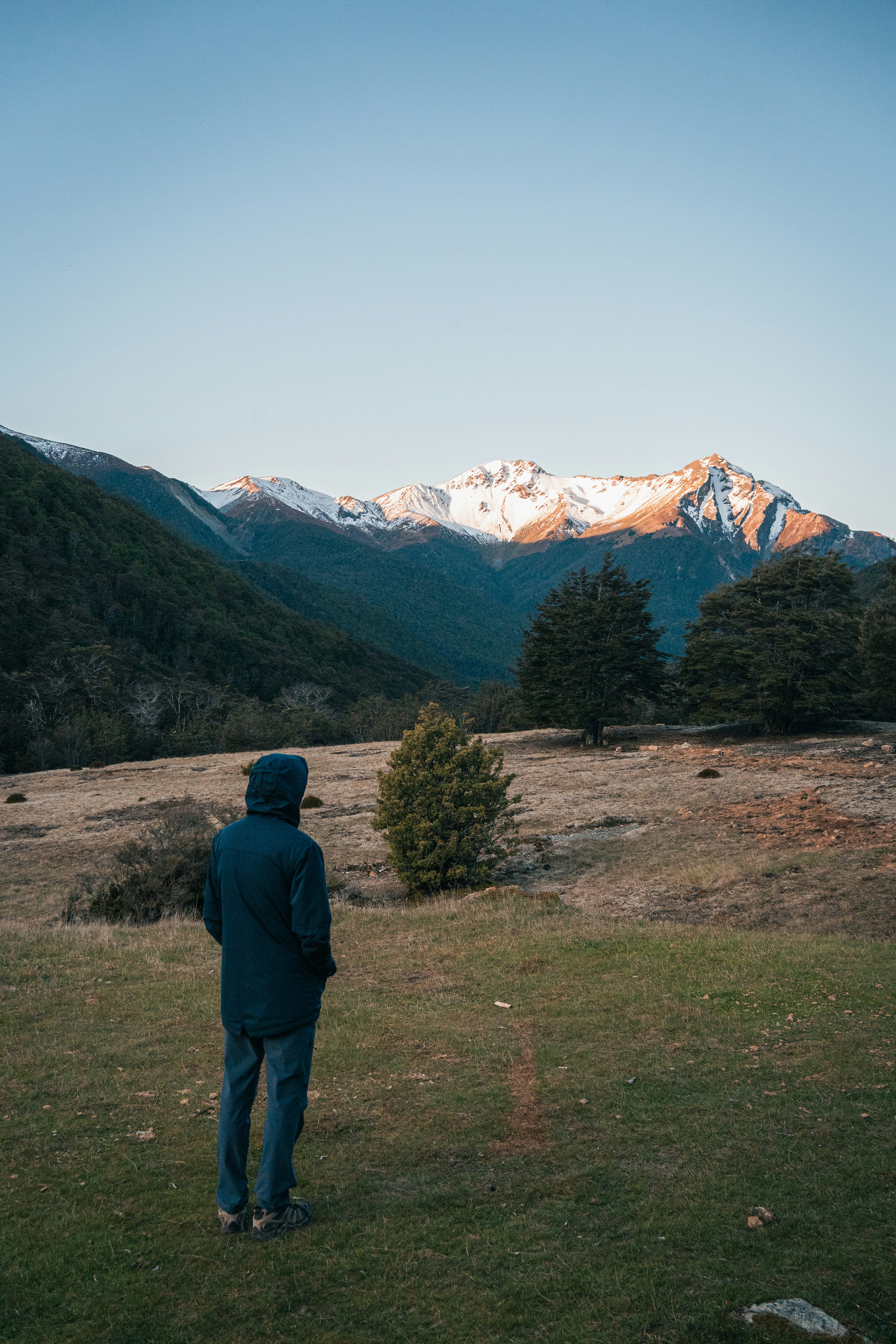 A solitary wanderer at the rim of snow-dusted peaks