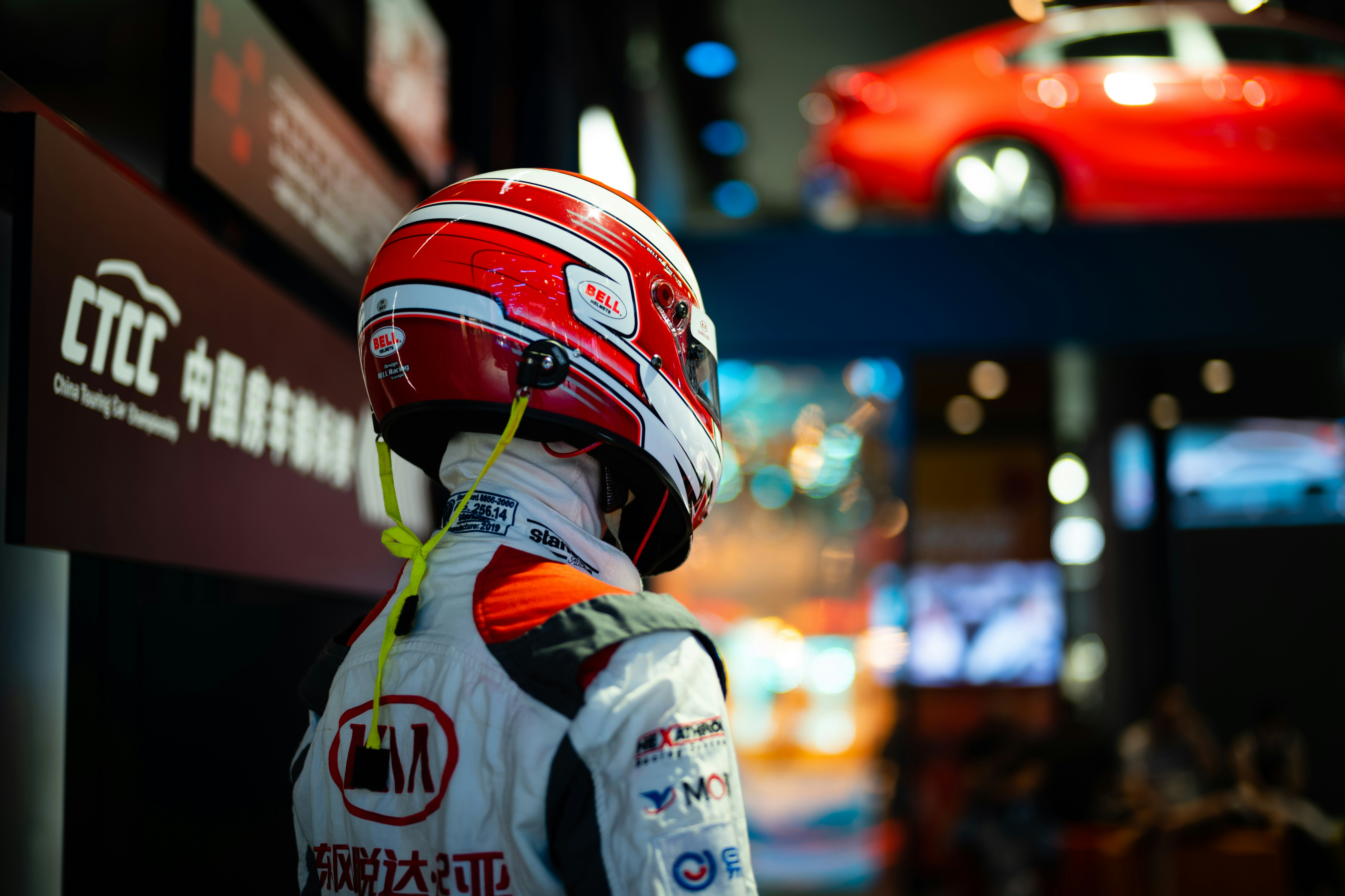 Red-Helmet Racer in a Car Showroom