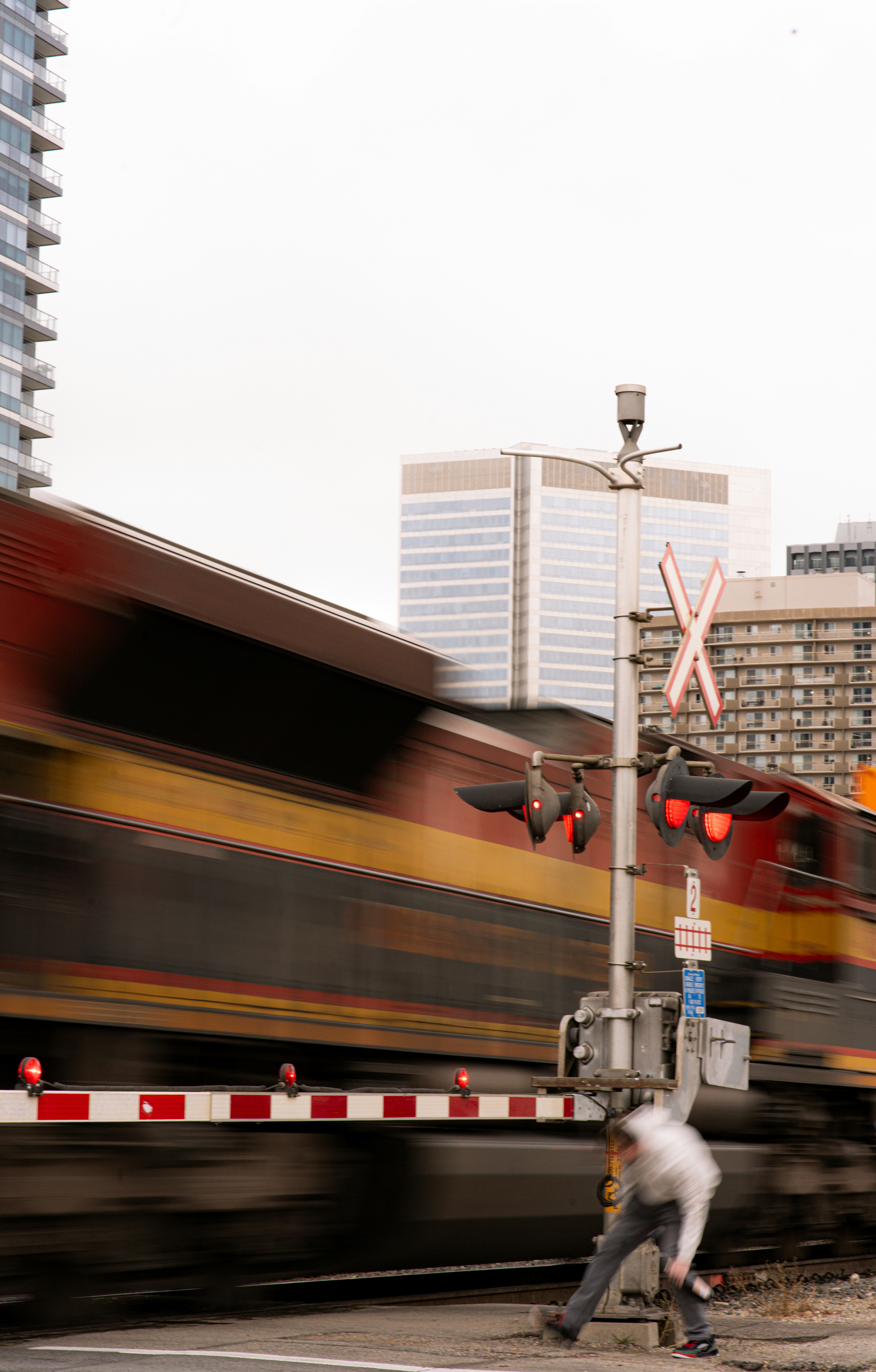 Rush at the Crossing: A Blurred Train and a Figure in Transit