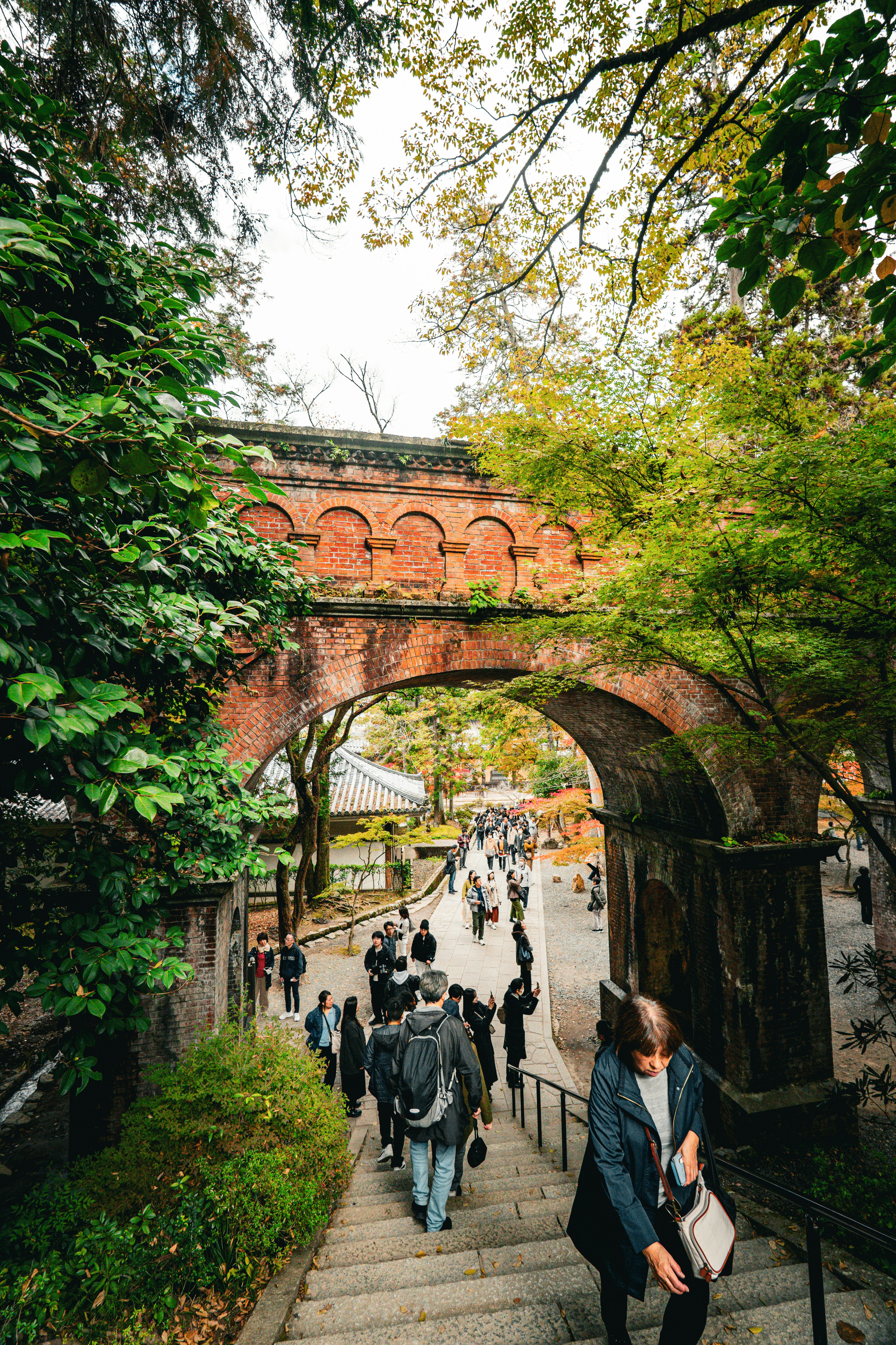 Crimson Archway Over a Bustling Autumn Staircase