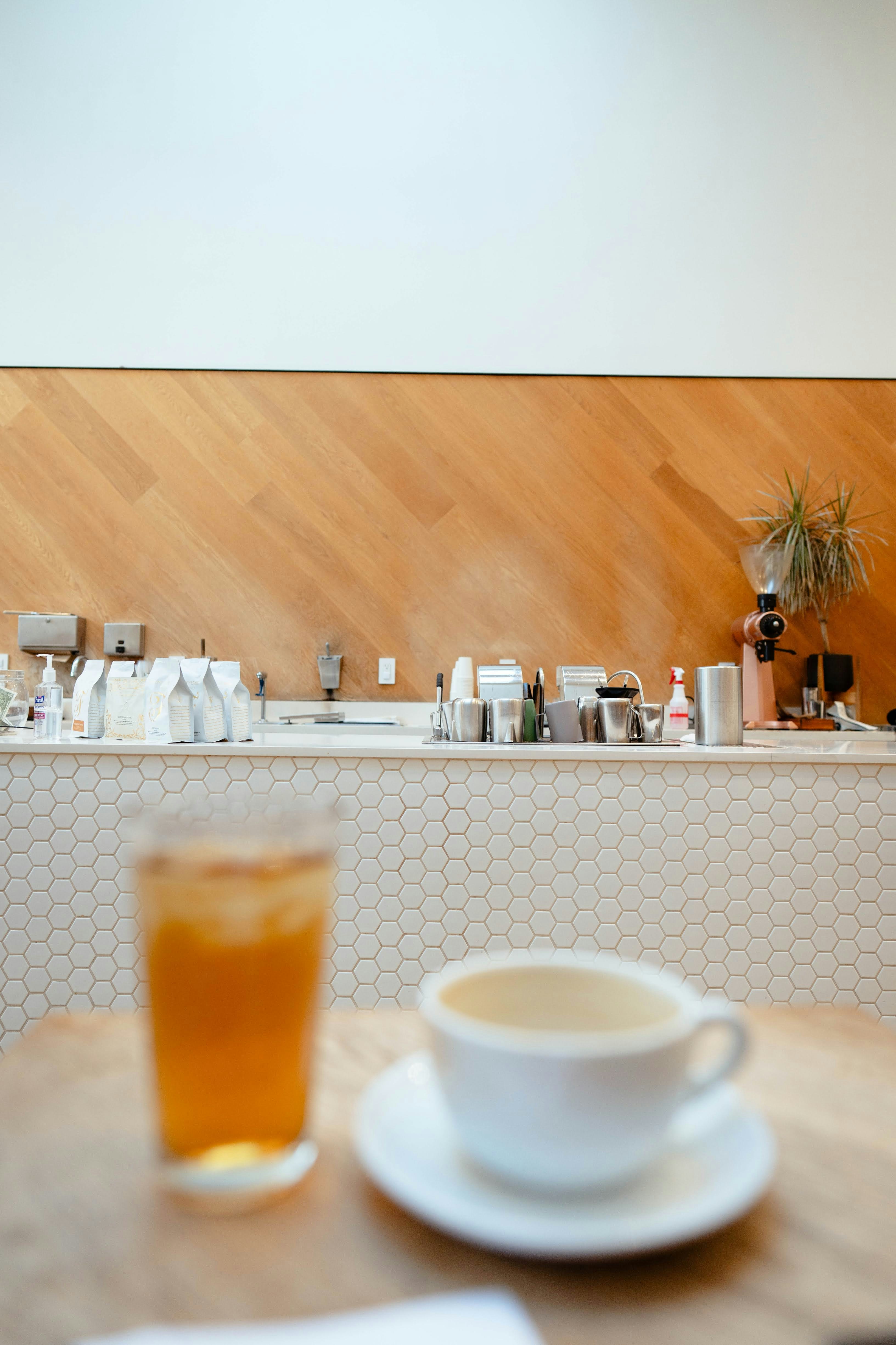 Cafe Minimal: Coffee Cup and Iced Tea on a Warm Wood Counter