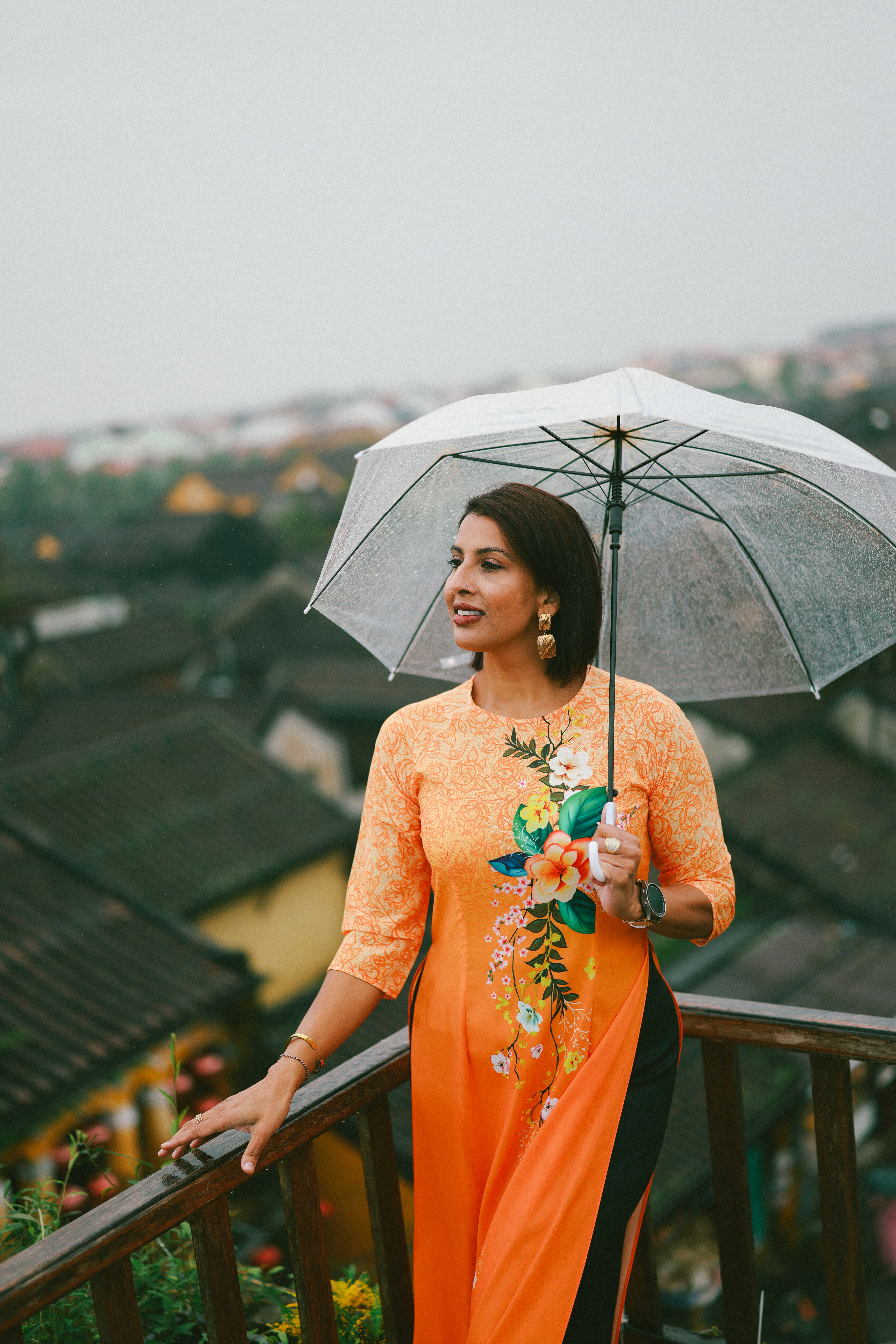 Amber Silk on the Balcony: Portrait in Orange Floral Dress Under an Umbrella