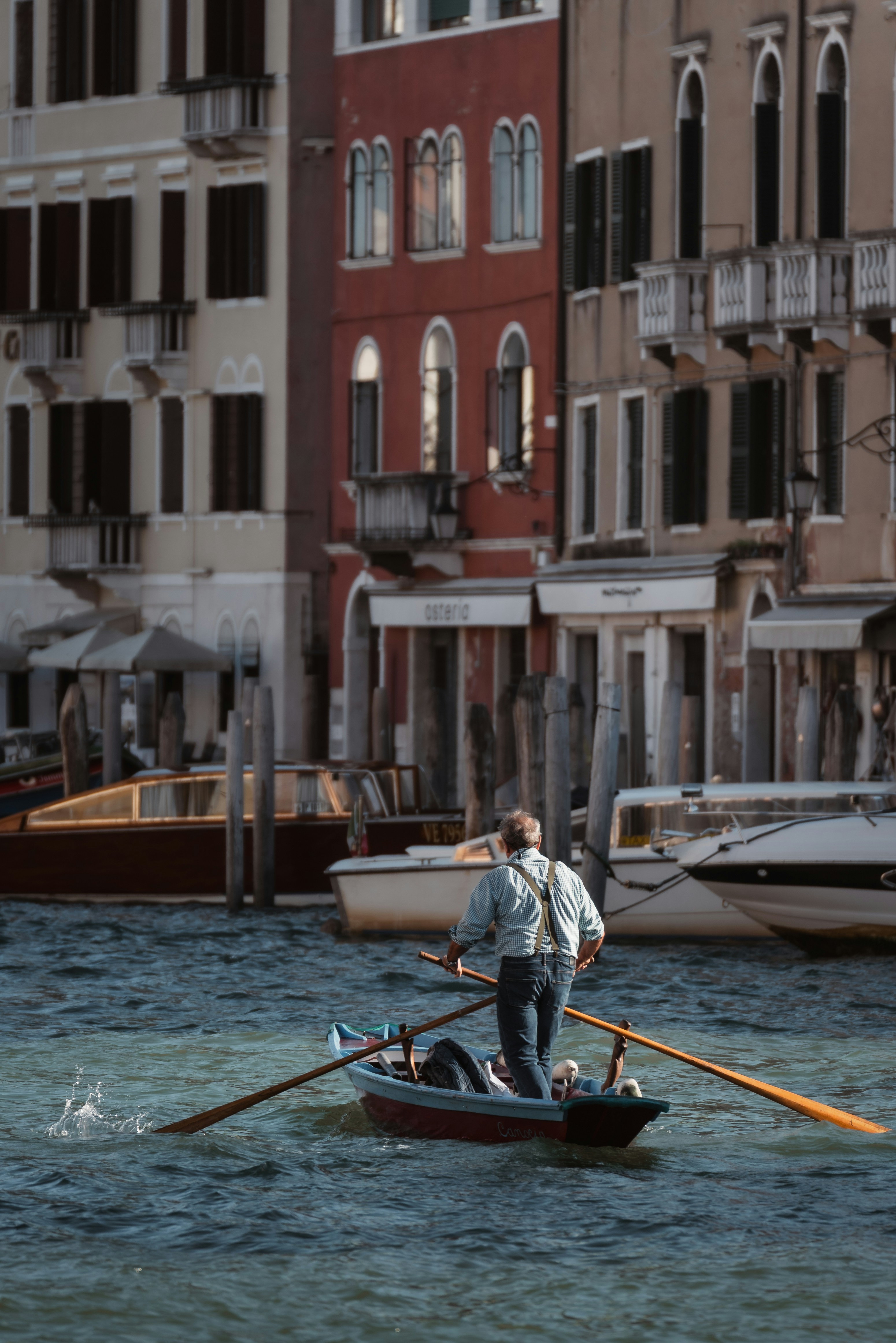 Quiet Crossing: A Gondolier Steering Venice's Colorful Canals