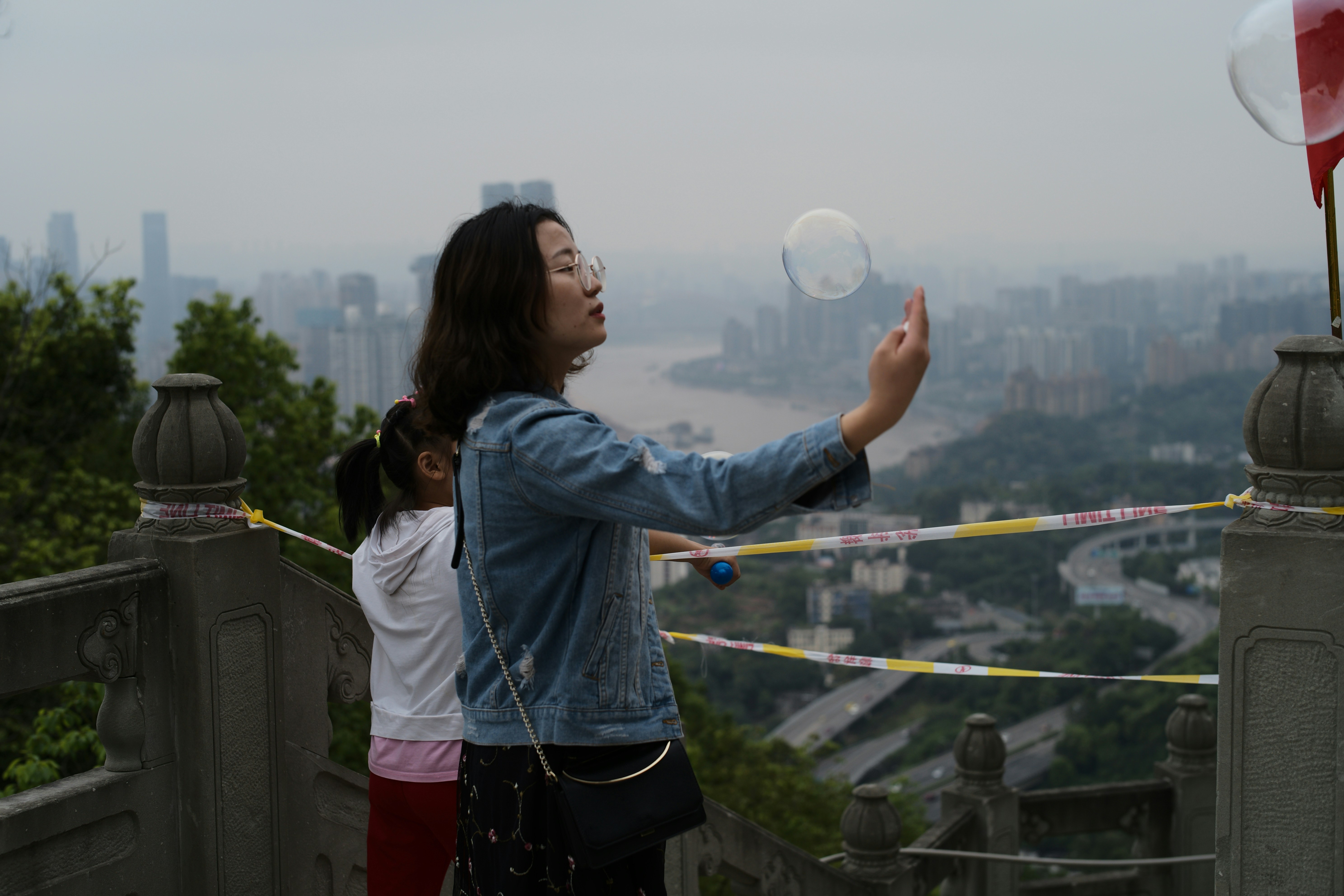 Bubble at the Balcony: Denim-clad Moment Over a Distant City