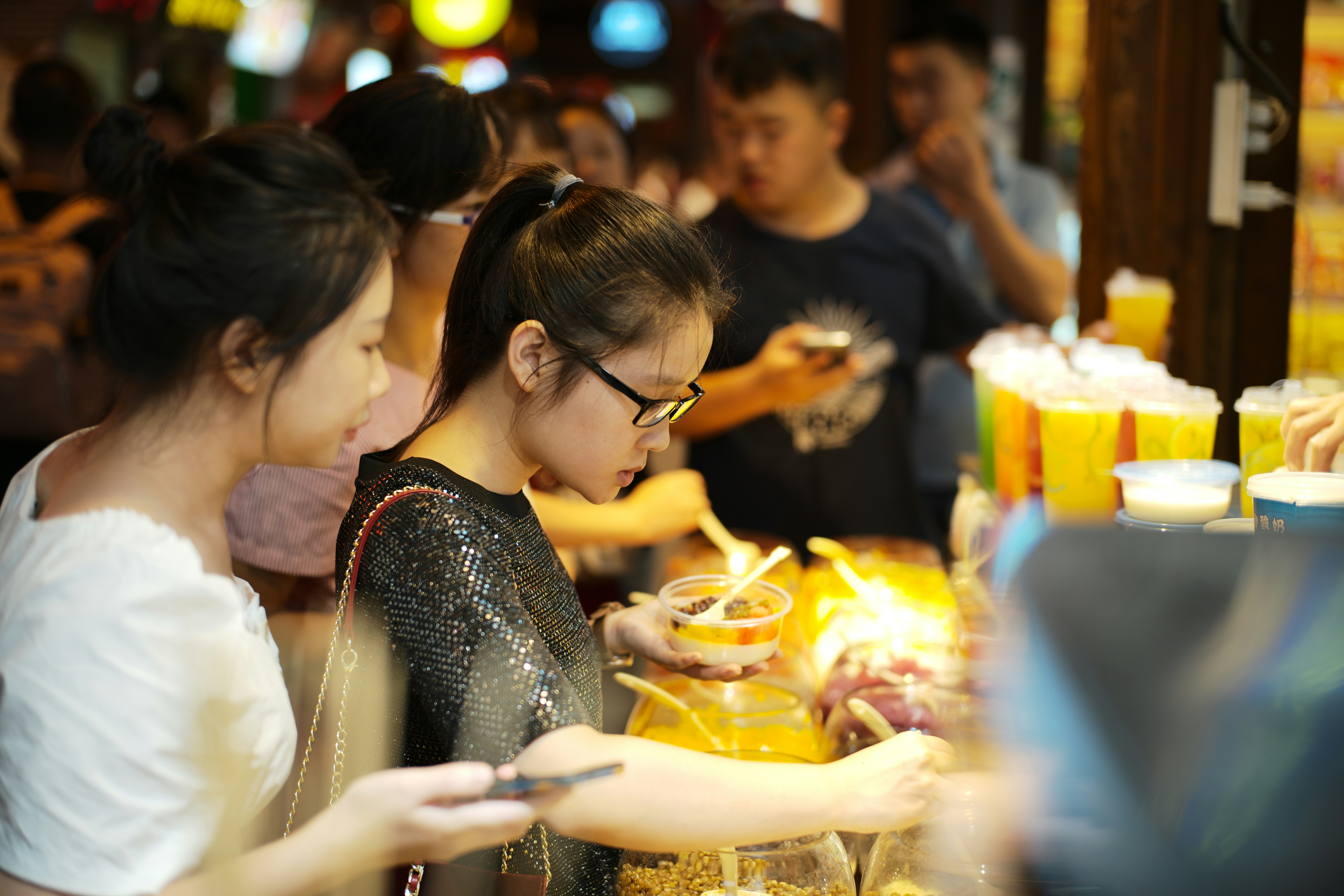 Glasses and steam: a quiet focus at a bustling street stall