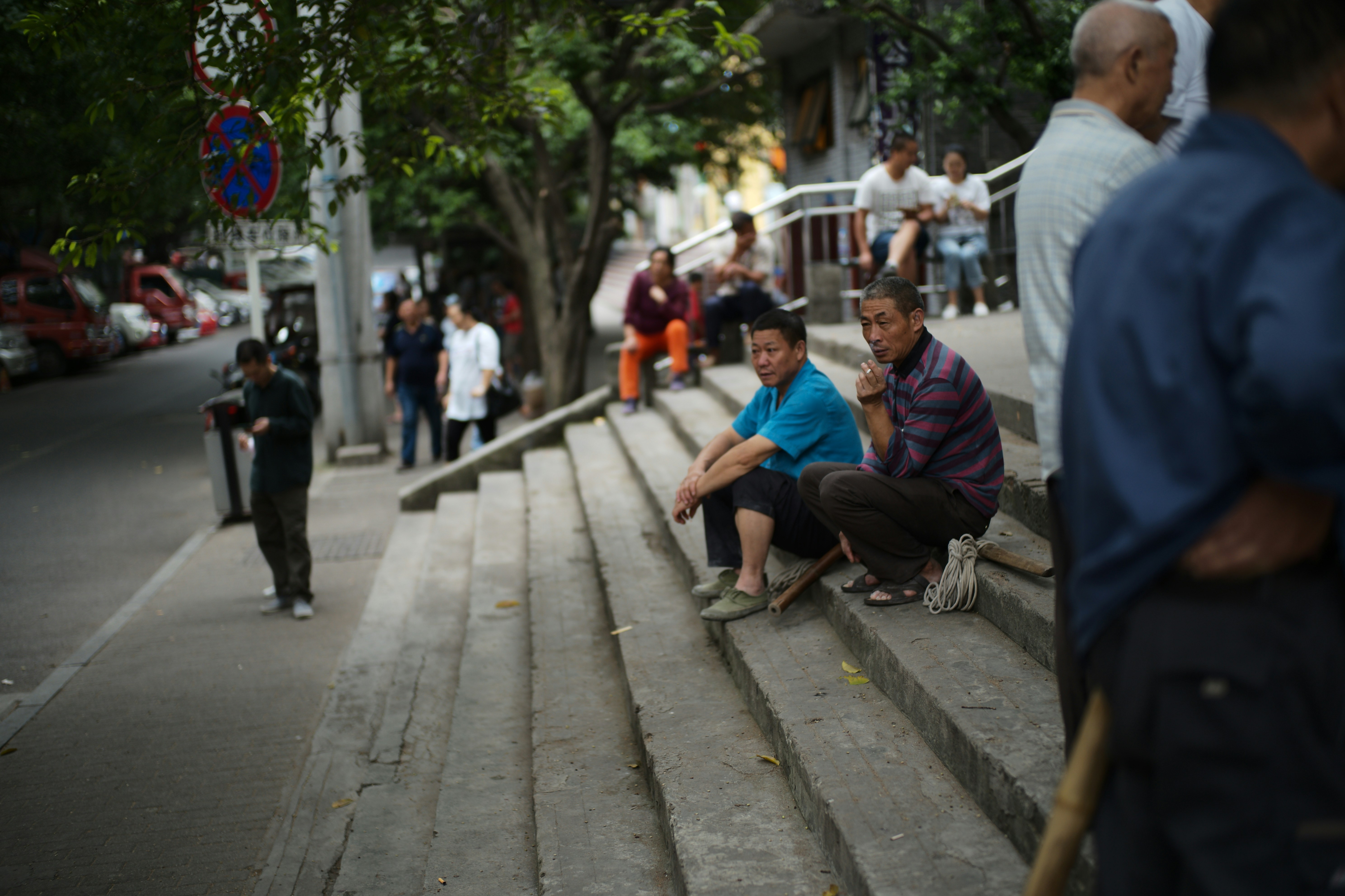 Three Men on the Steps: A Quiet Moment on a Busy Street