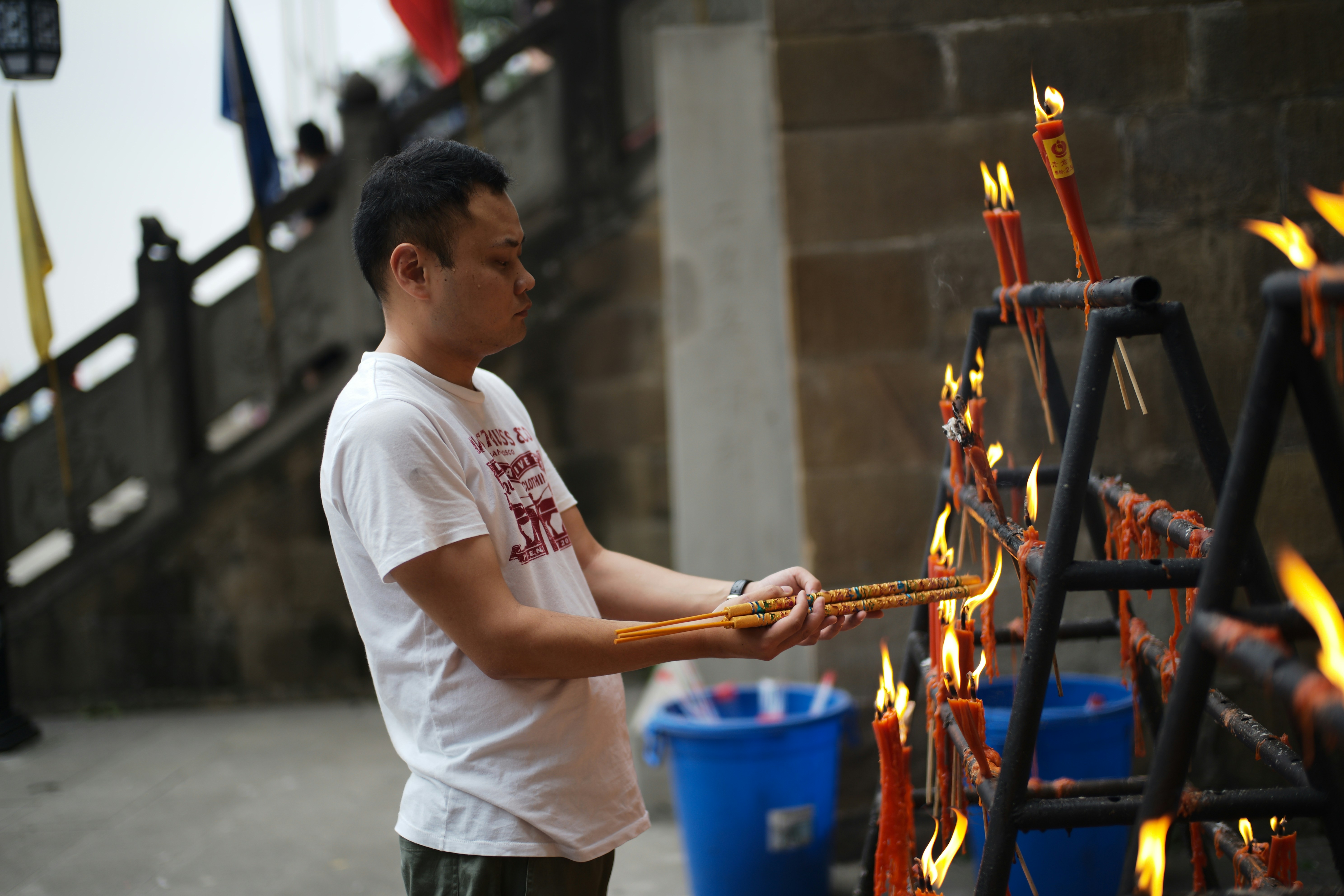 Faithful Flame: A devotee tending the temple torches at dusk