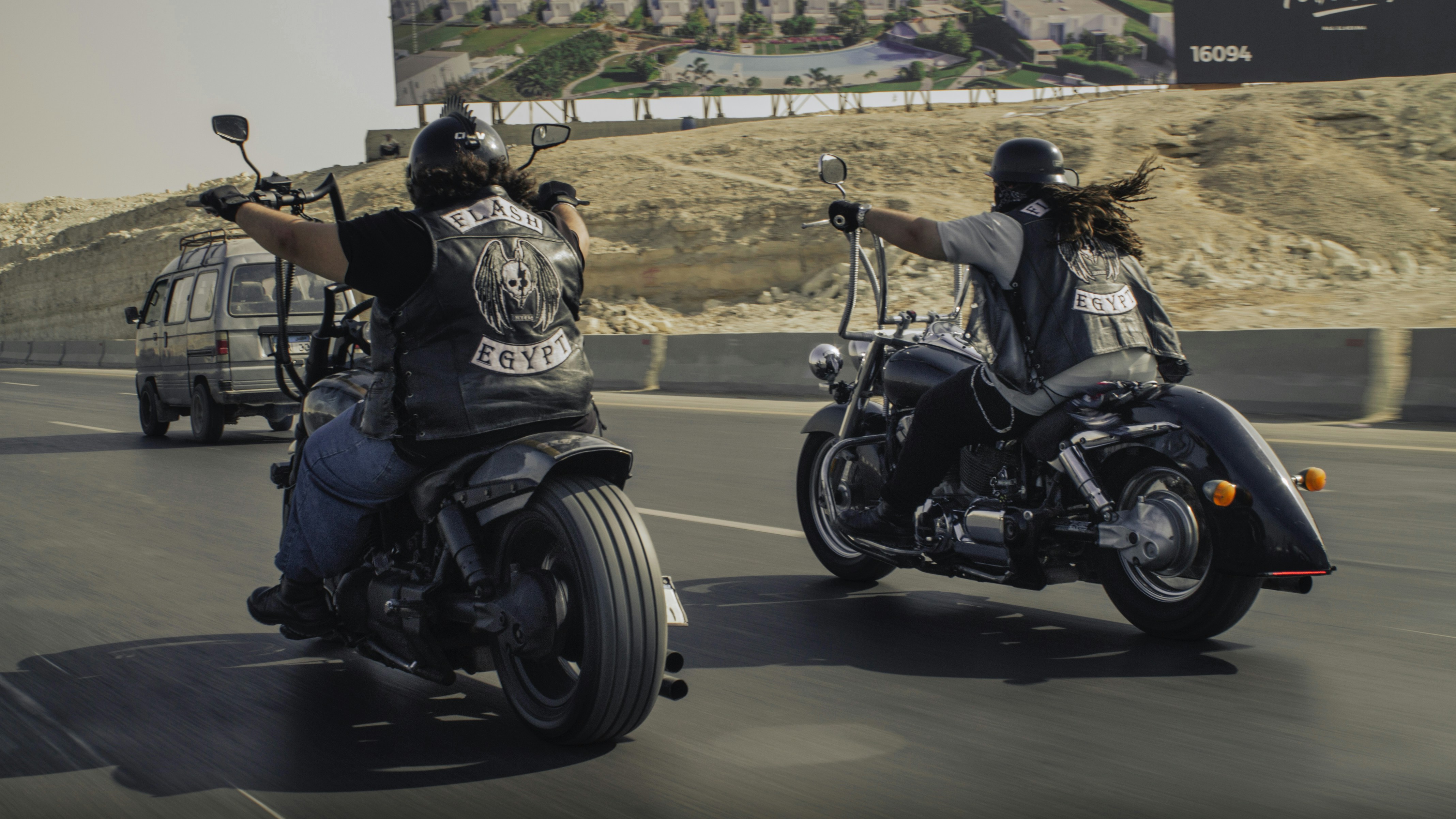 Twin Harleys Glide Past a Desert Billboard