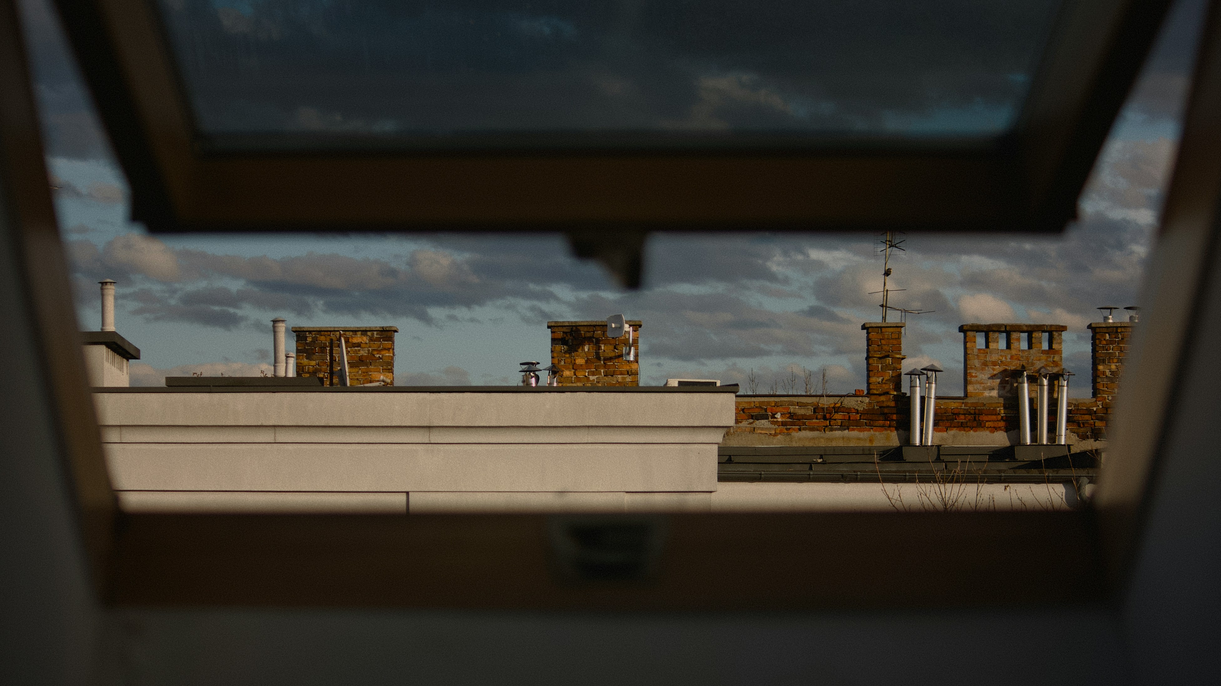 Framed Rooftops: Brick Chimneys Beneath an Open Sky