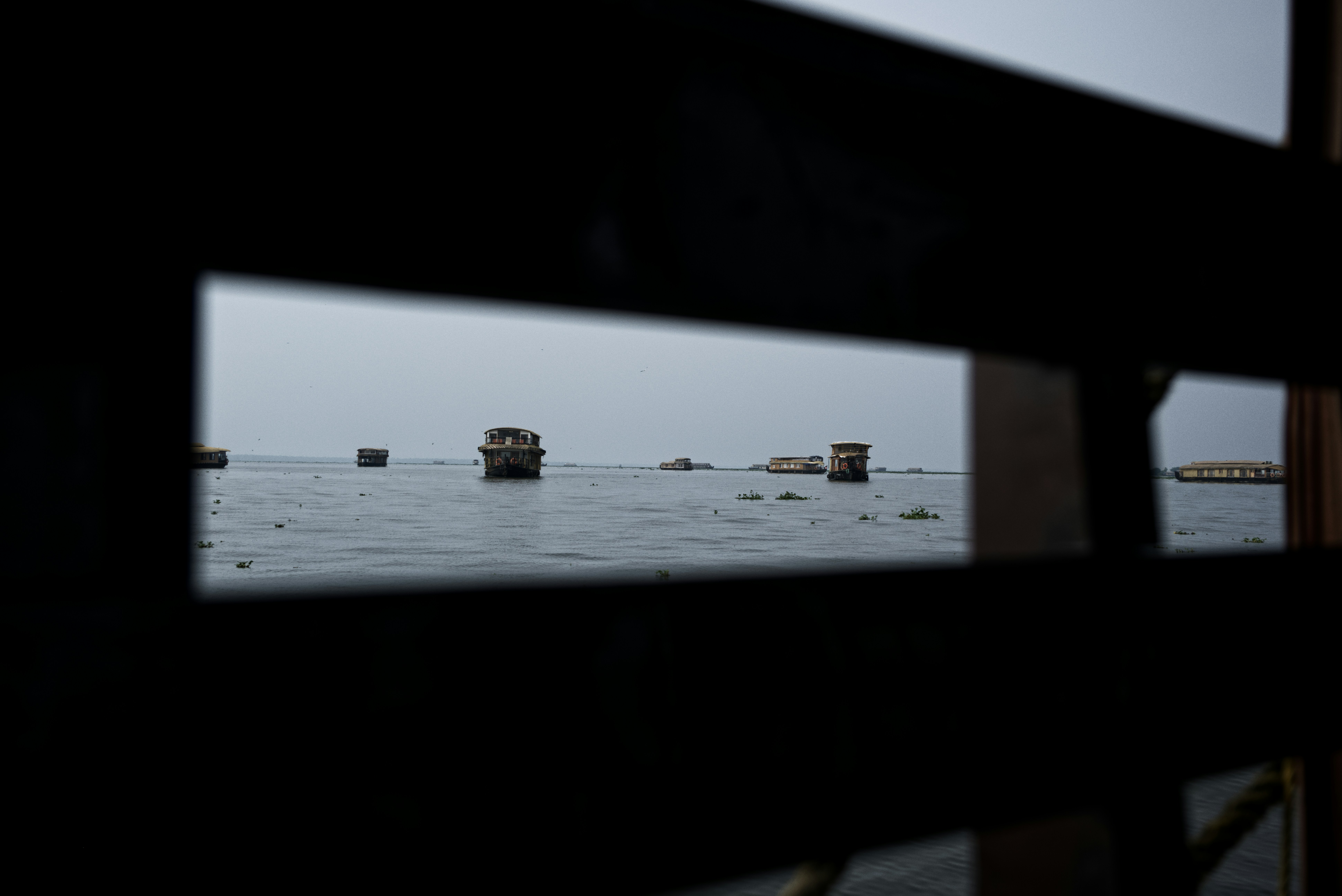 Horizon Between Slats: Boats on a Quiet Sea