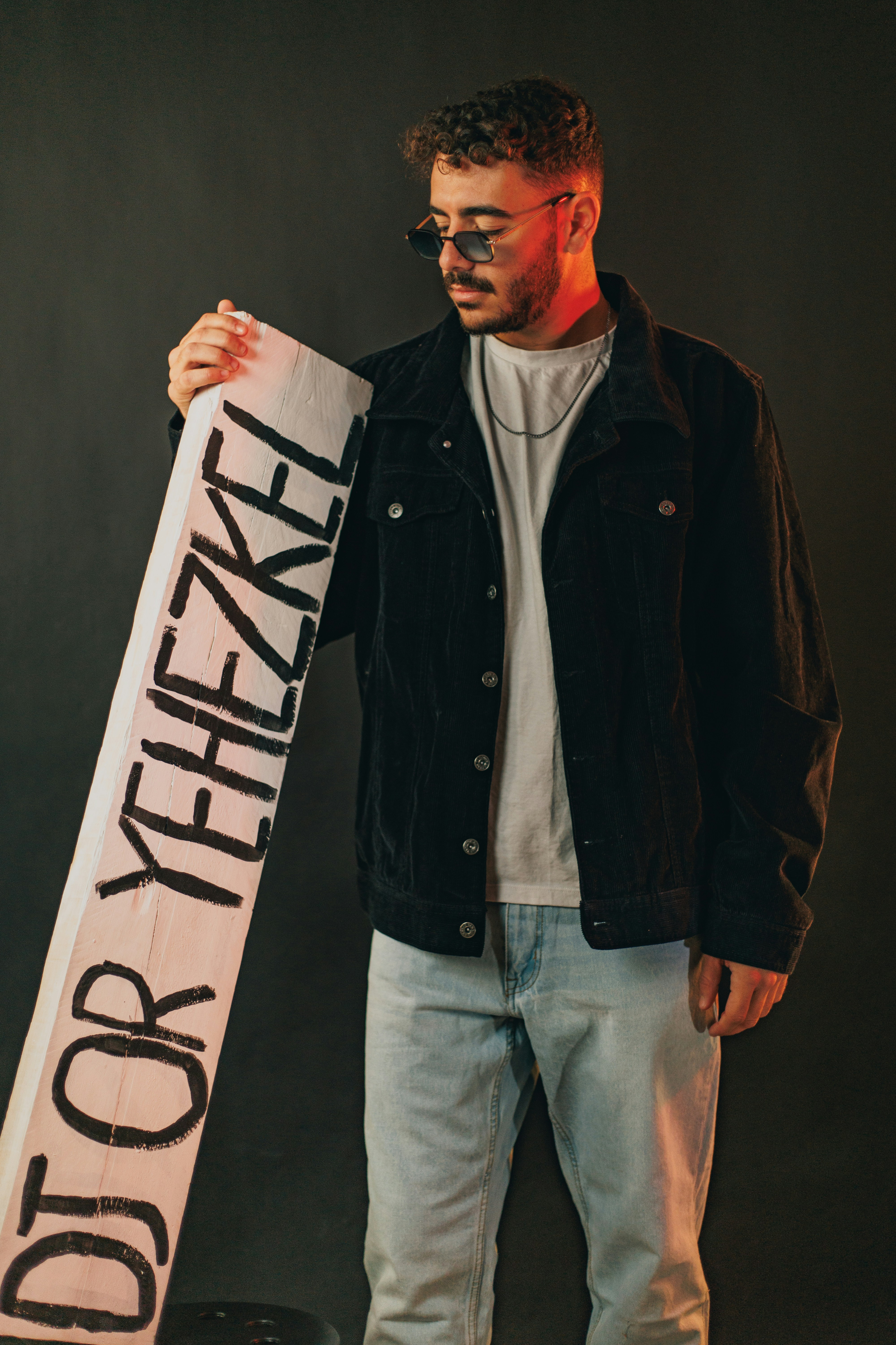 Holding the Line: A Street-Style Portrait with a Leaning Banner