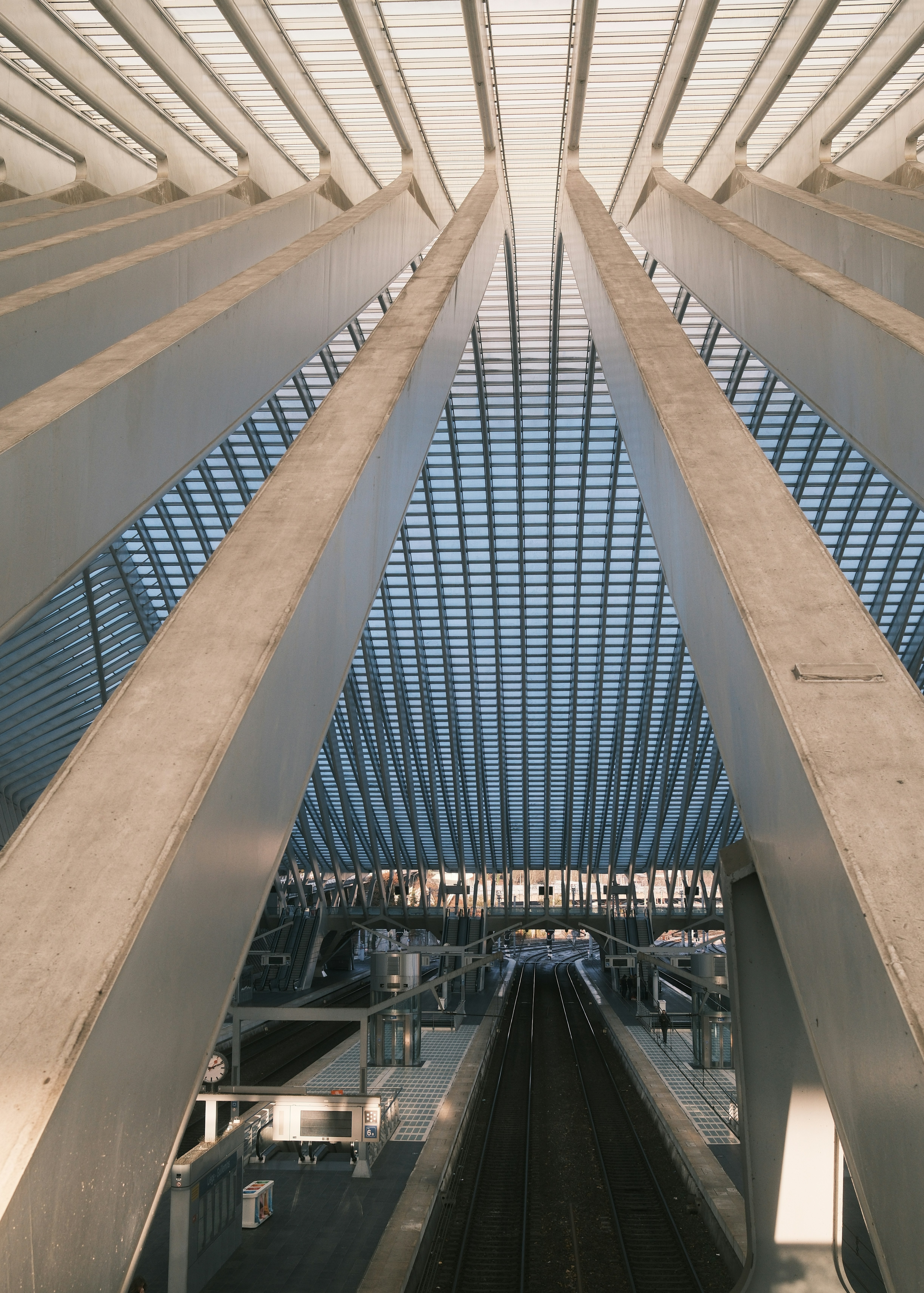 Liège-Guillemins Railway Station, designed by acclaimed Spanish architect Santiago Calatrava and officially opened in 2009, stands as one of Europe’s most breathtaking examples of contemporary architecture. Replacing a 19th-century structure, its monumental vaulted roof—constructed from 39,000 tonnes of steel and expansive glass panels—spans 200 metres without internal supports, soaring up to 35 metres high. The fluid, wave-like form evokes movement and light, bathing the five platforms and nine tracks in natural illumination. Serving high-speed TGV, Thalys, and ICE trains, the station handles