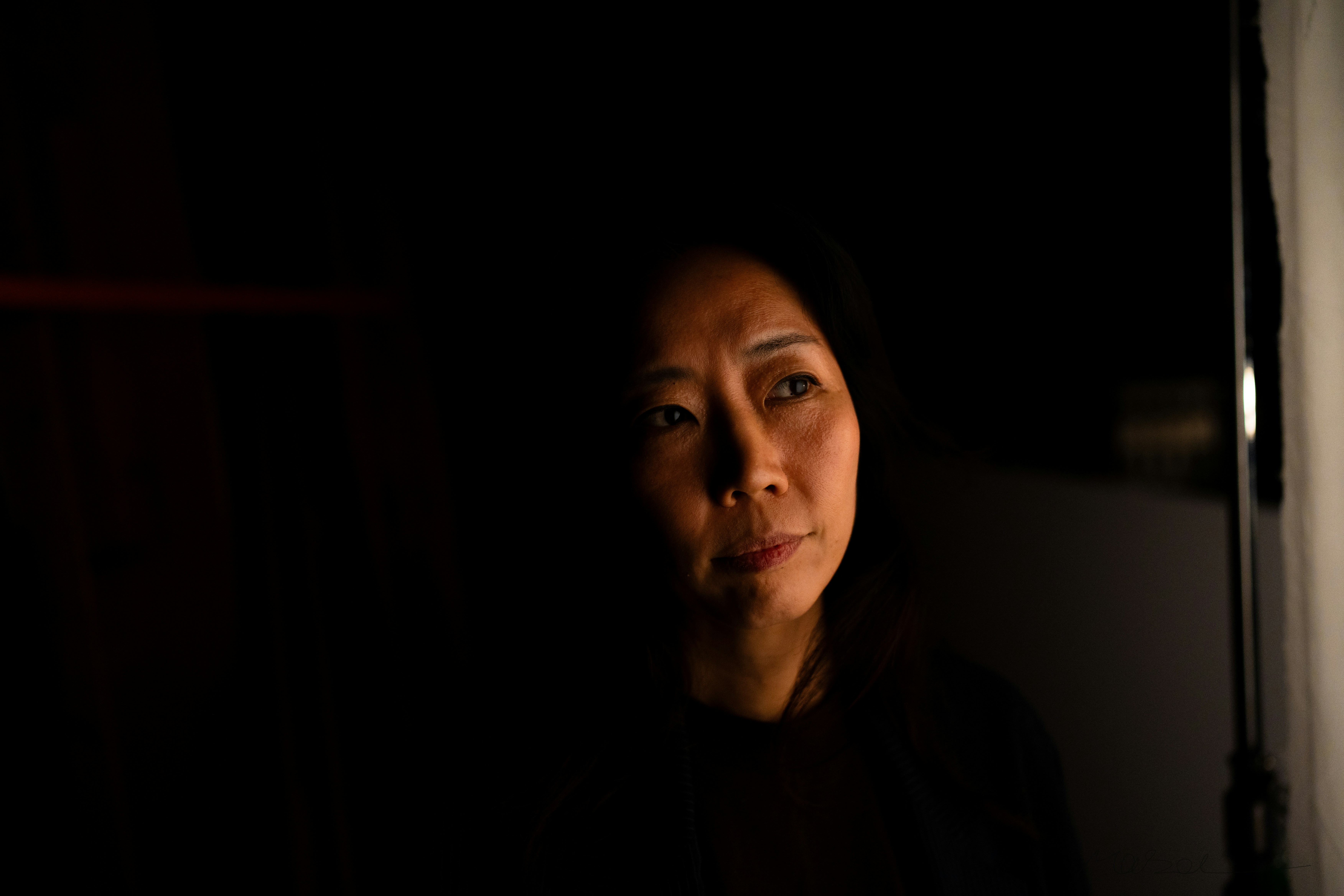 A Quiet Gaze in a Dim Studio