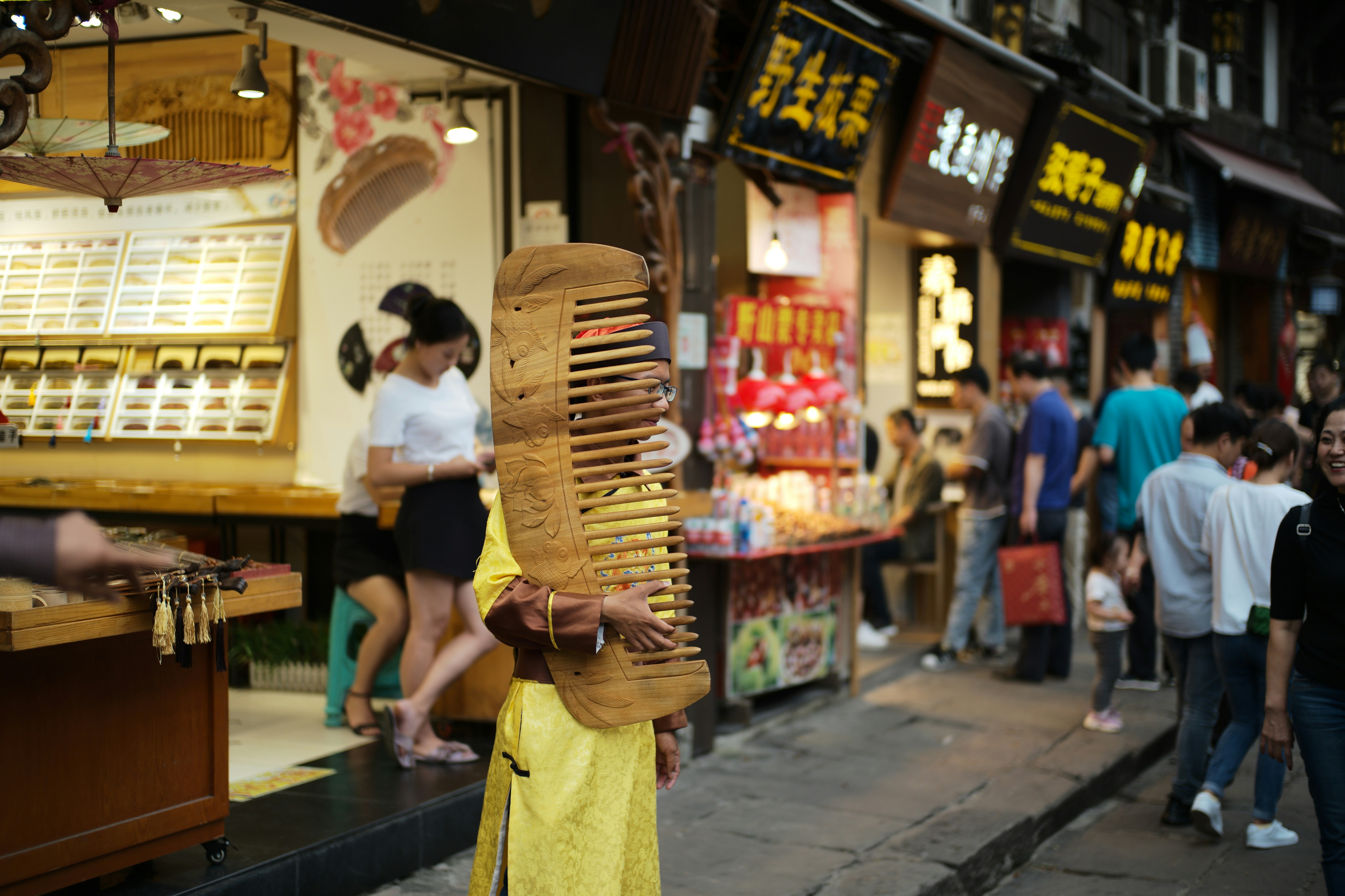 The Wooden Mask: A Quiet Figure Amid a Bustling Market