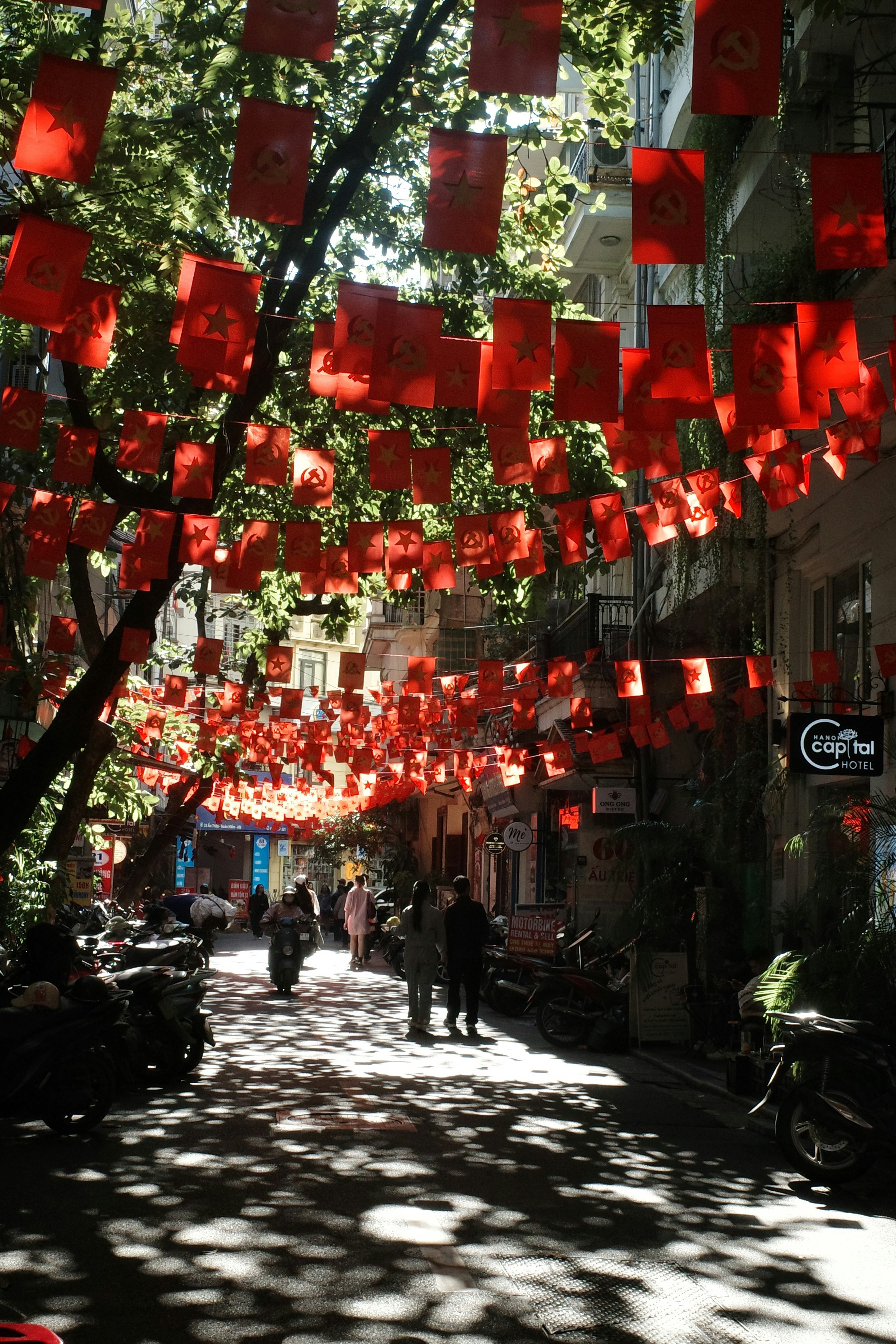 Red Flags Draped Across a Sunlit City Street