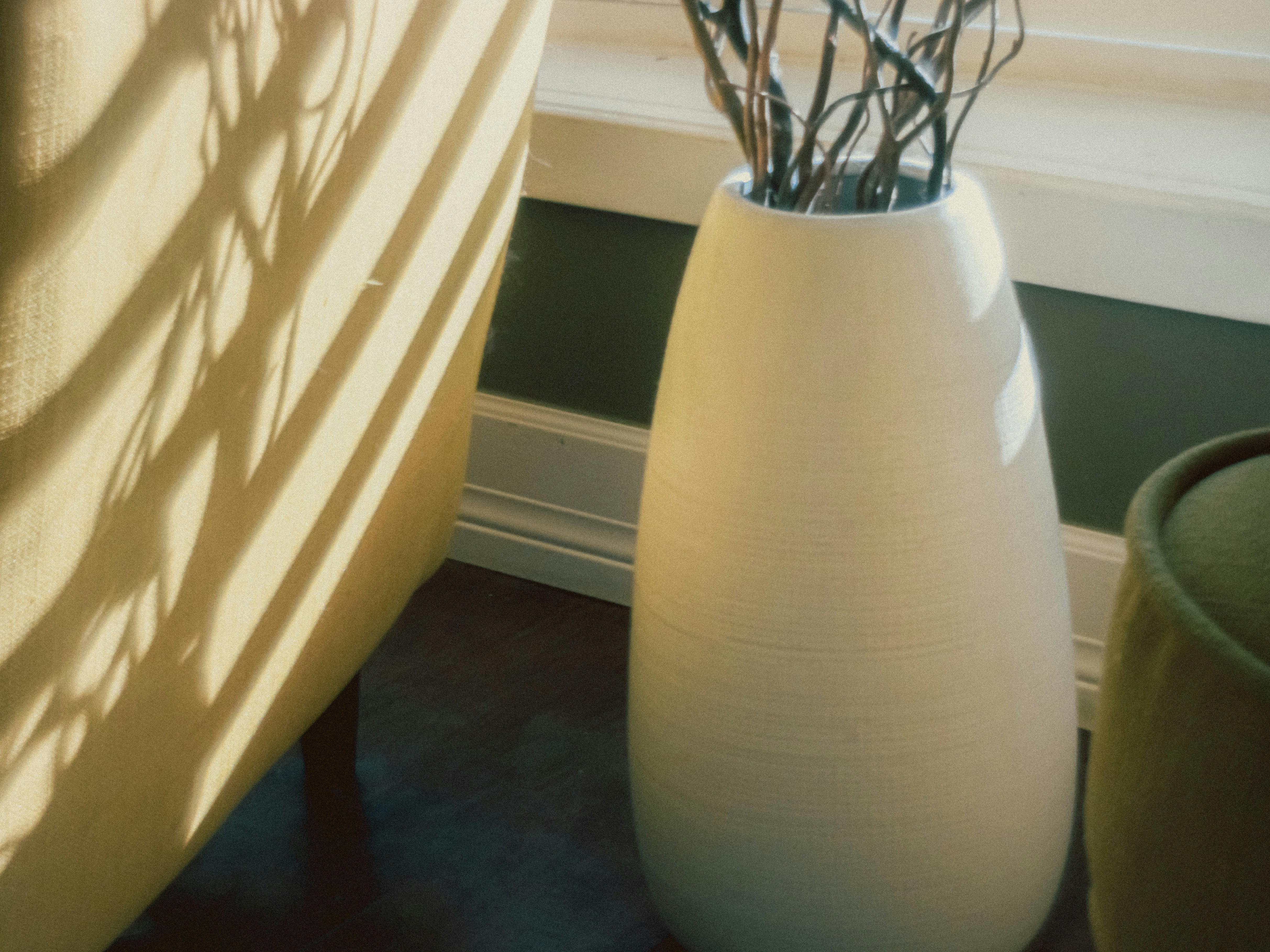 vase by yellow living room sofa and sunny window