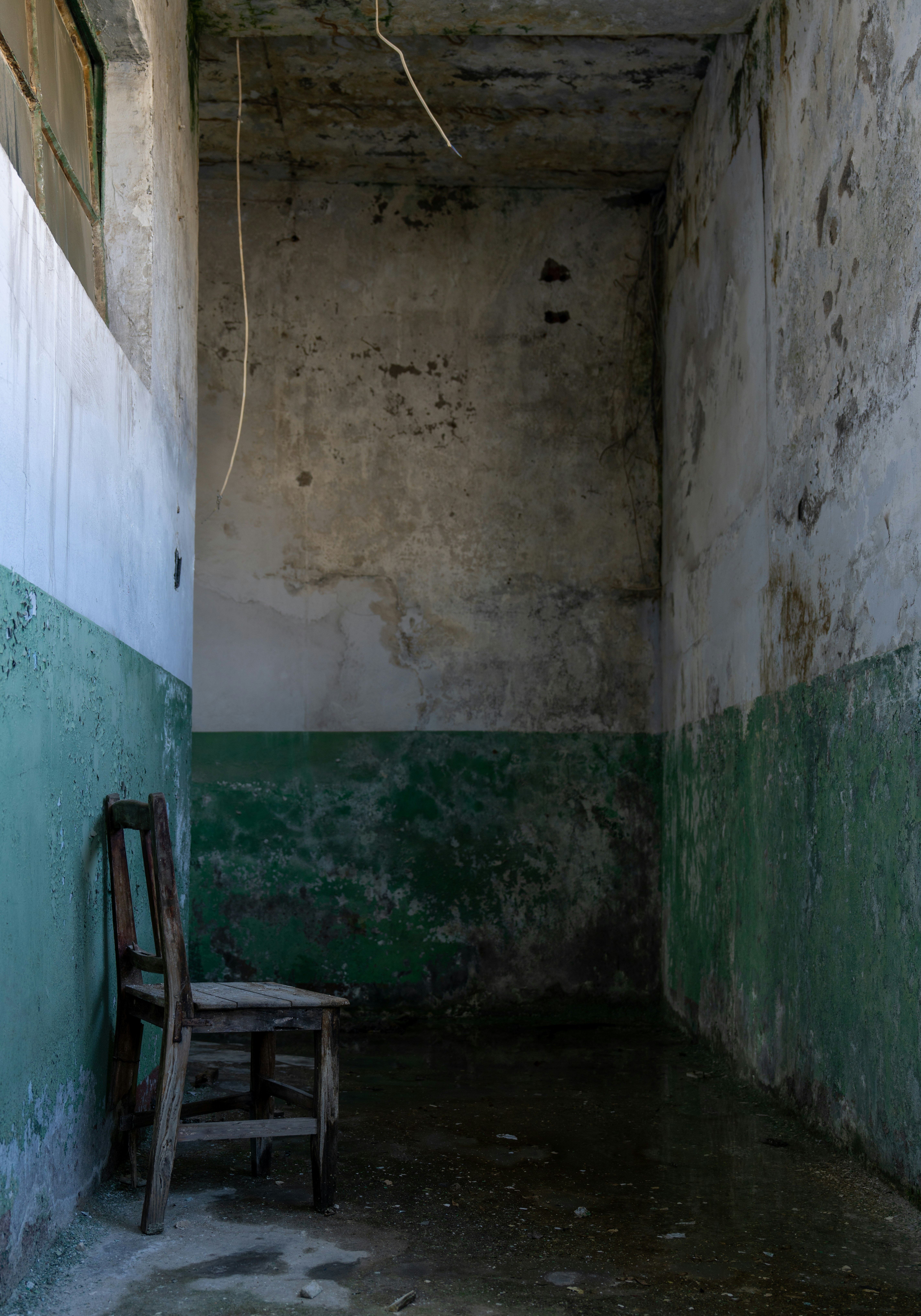 Left-leaning Chair in a Green-Washed Chamber