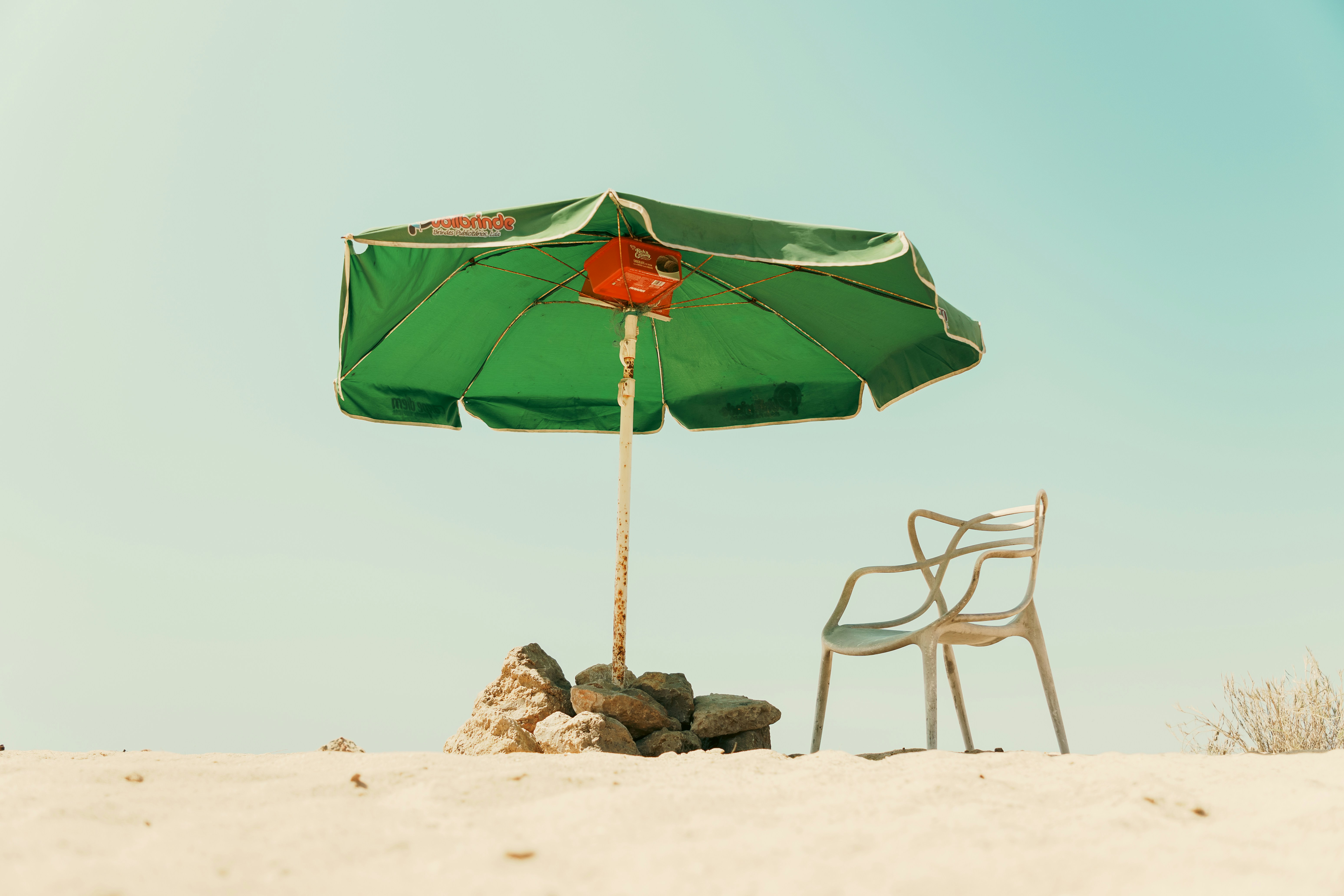 A Lone Green Umbrella Holds Court on a Quiet Shore