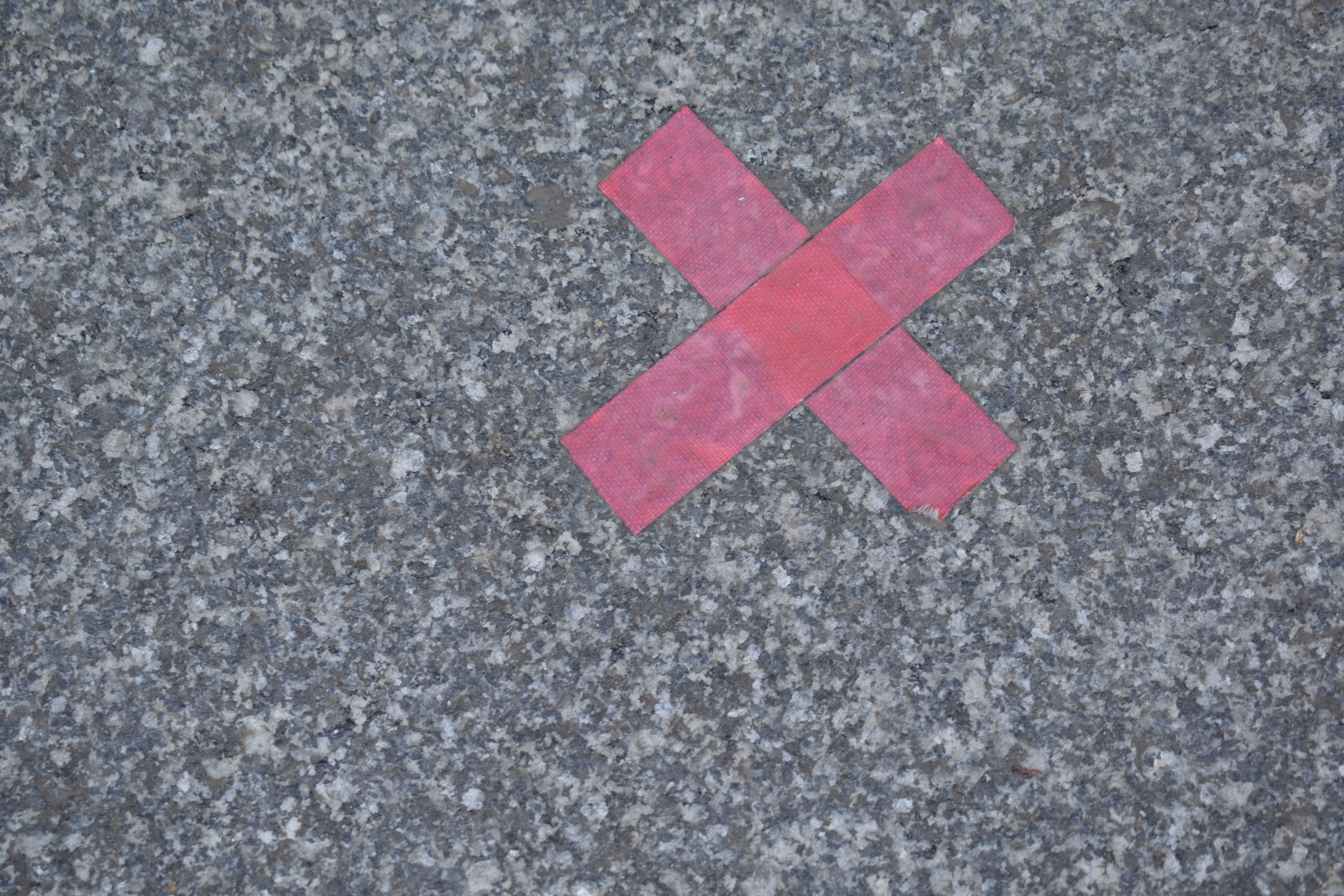 Scarlet X Mark on Weathered Concrete