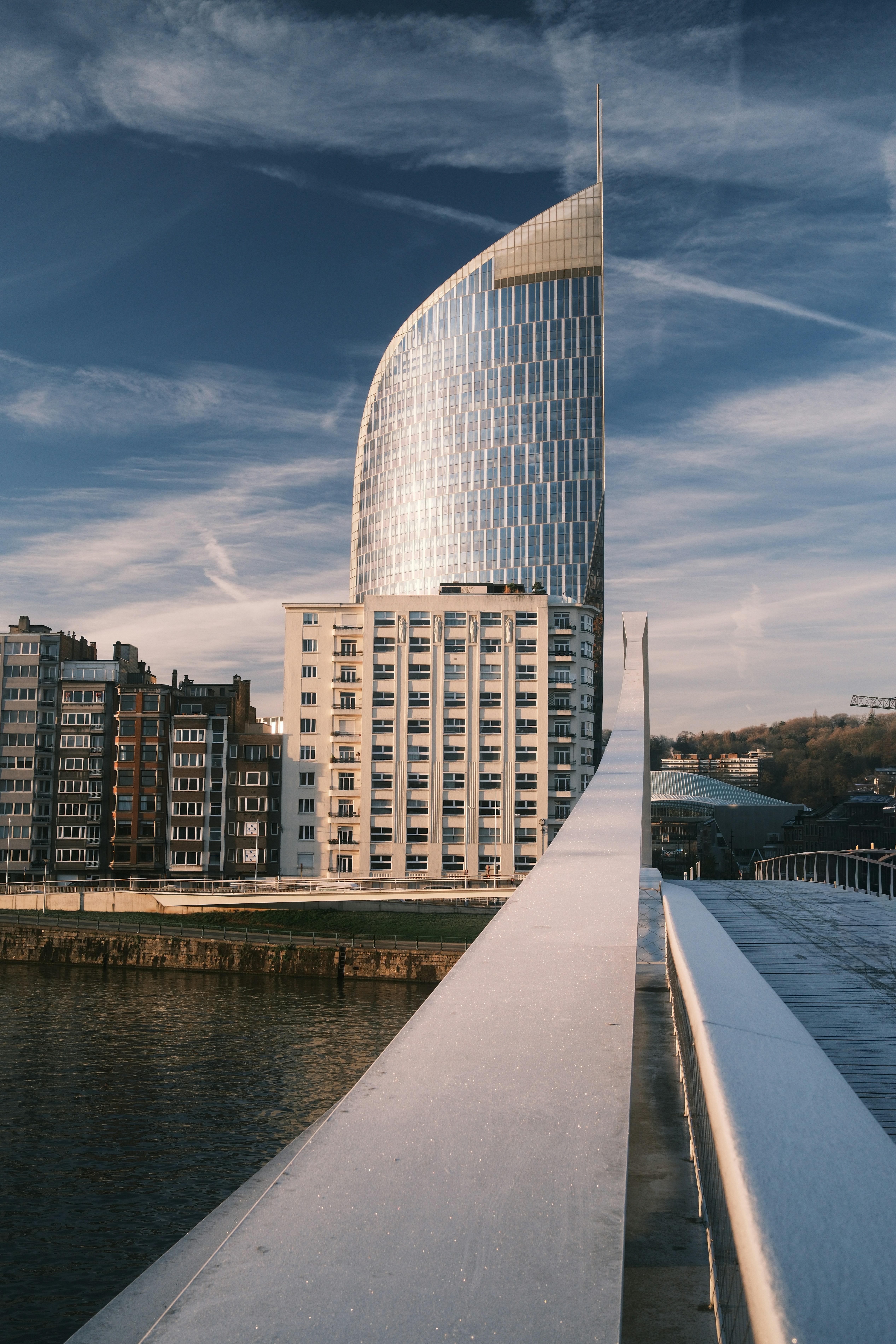 Glass-curved Tower Over the River: A Modern Bridge to Tomorrow