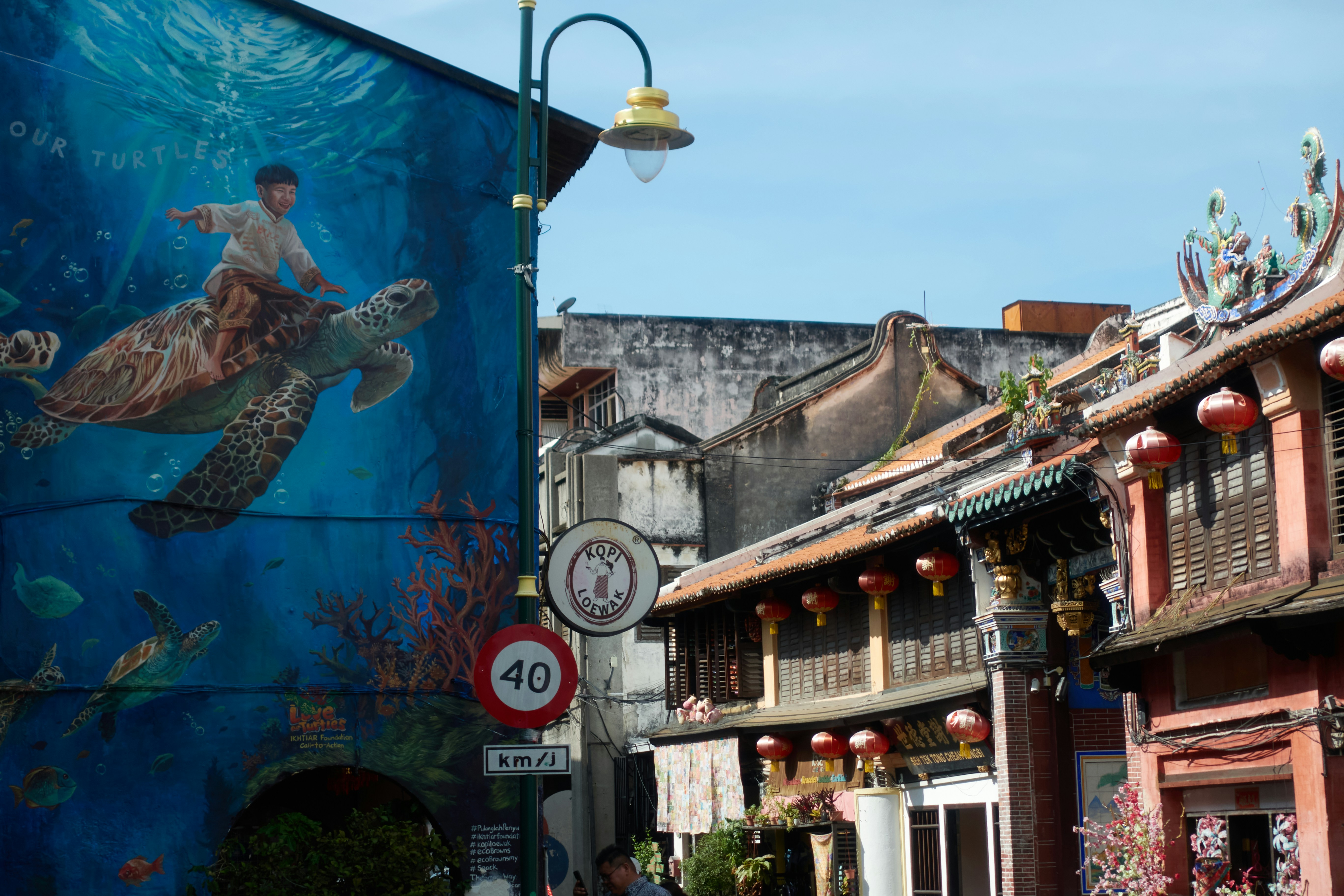Blue Tide Mural: A Boy on a Turtle Along a Lantern-Lit Street
