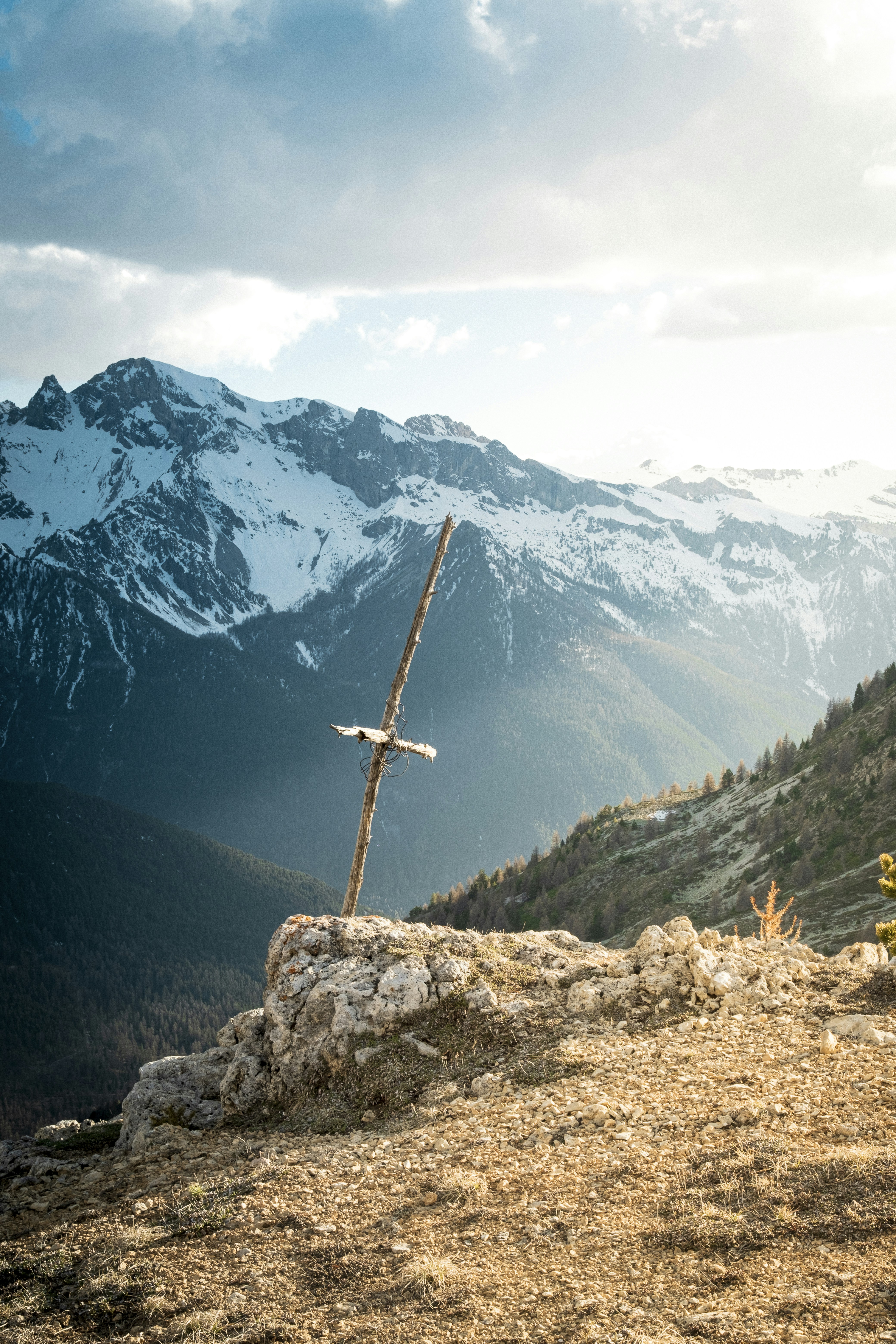 Lonely Cross on a Rocky Ridge Framing Snow-Capped Giants