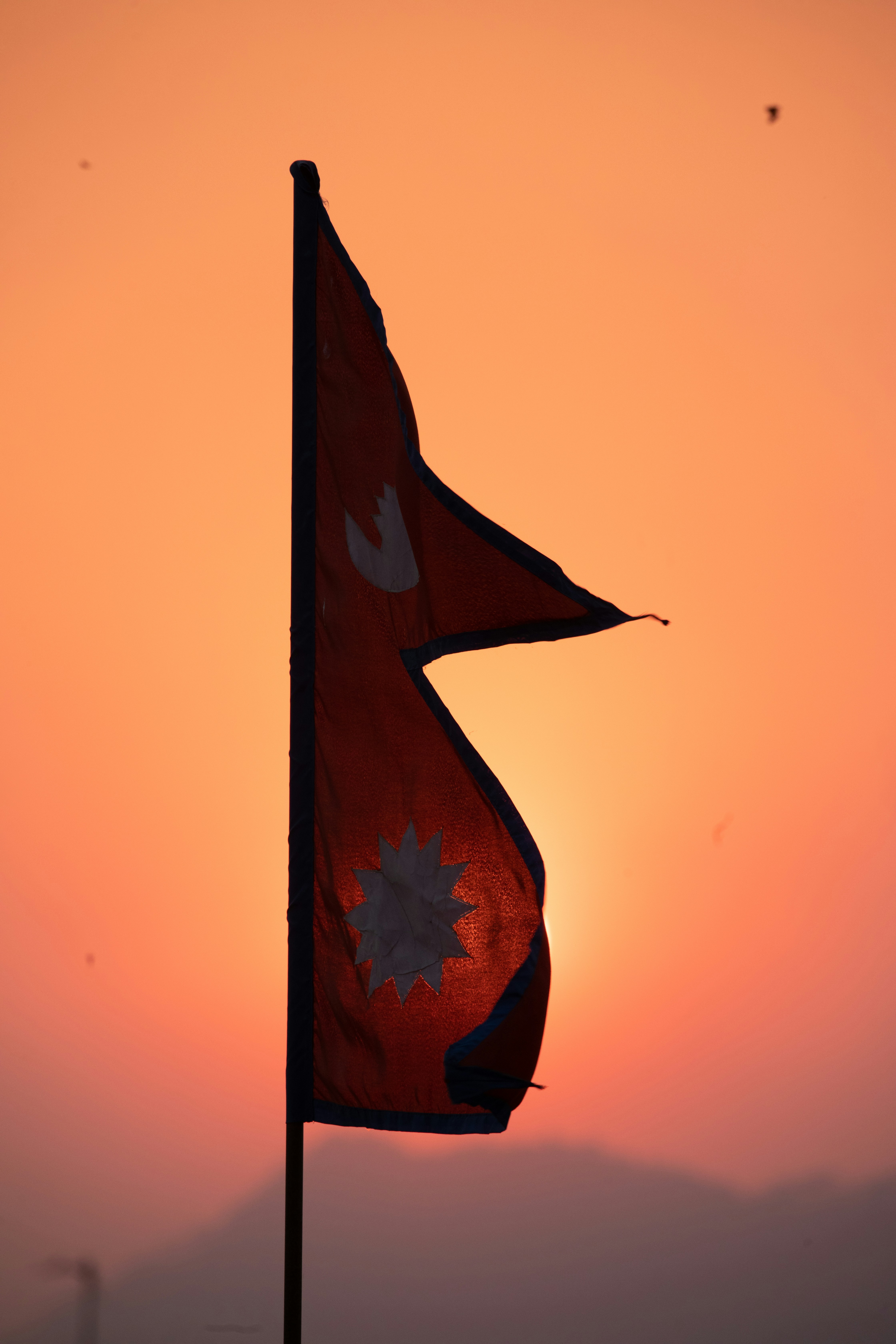 Amber Hour Banner: a lone flag silhouette against a sunset sky