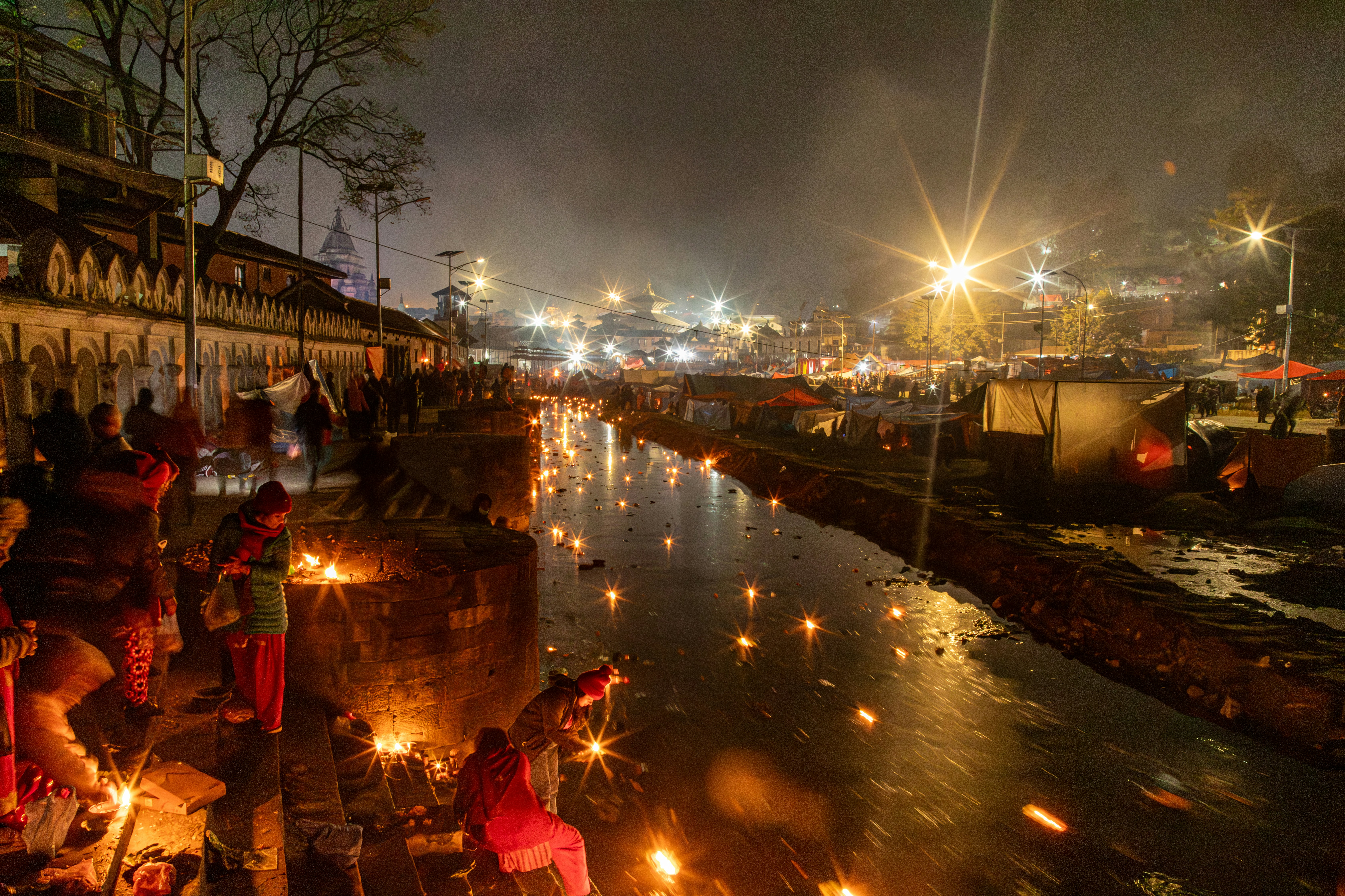 Candles Across the Riverbank: Firelight at a Night Market