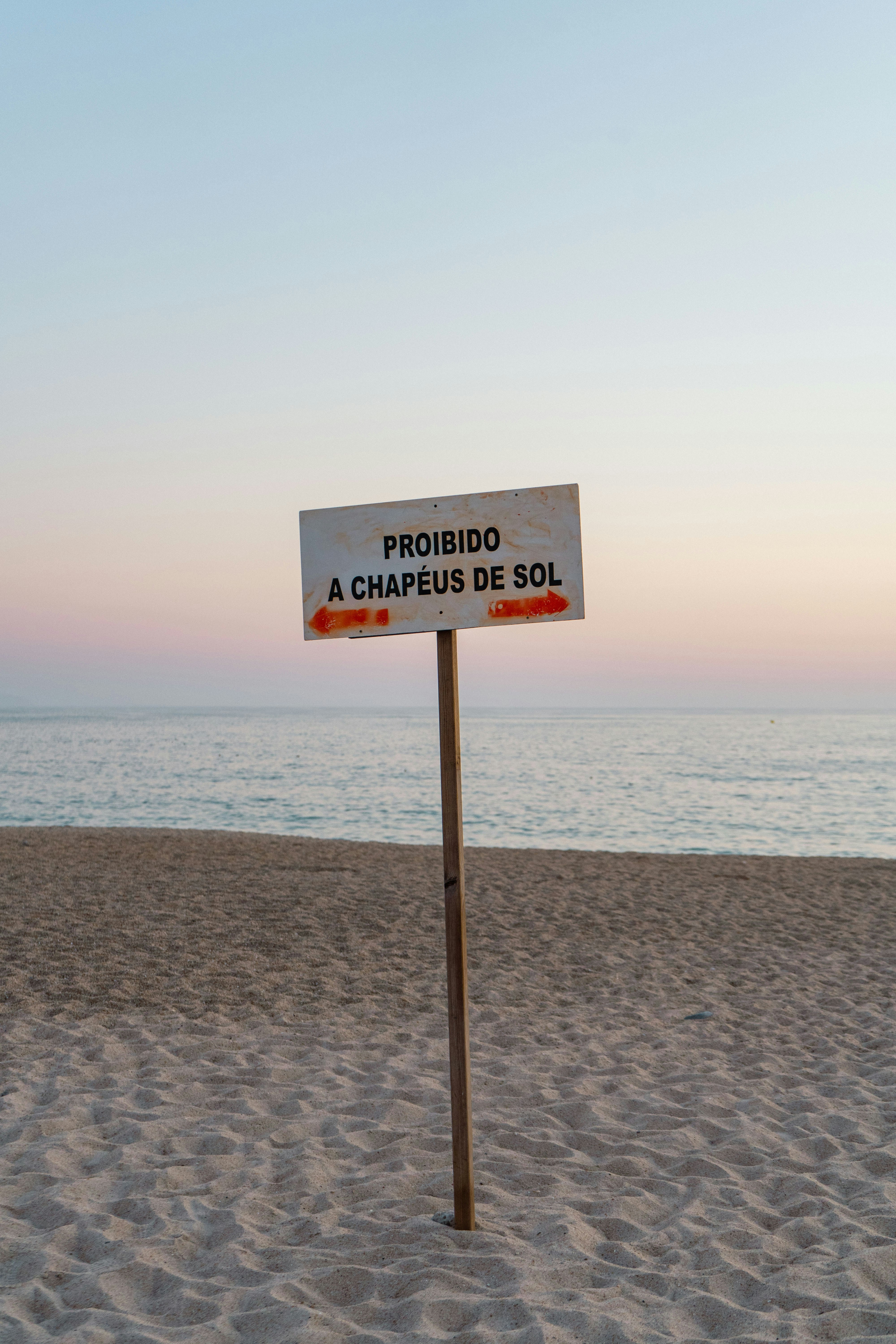No-Sun Hats Sign at Dusk by the Calm Sea